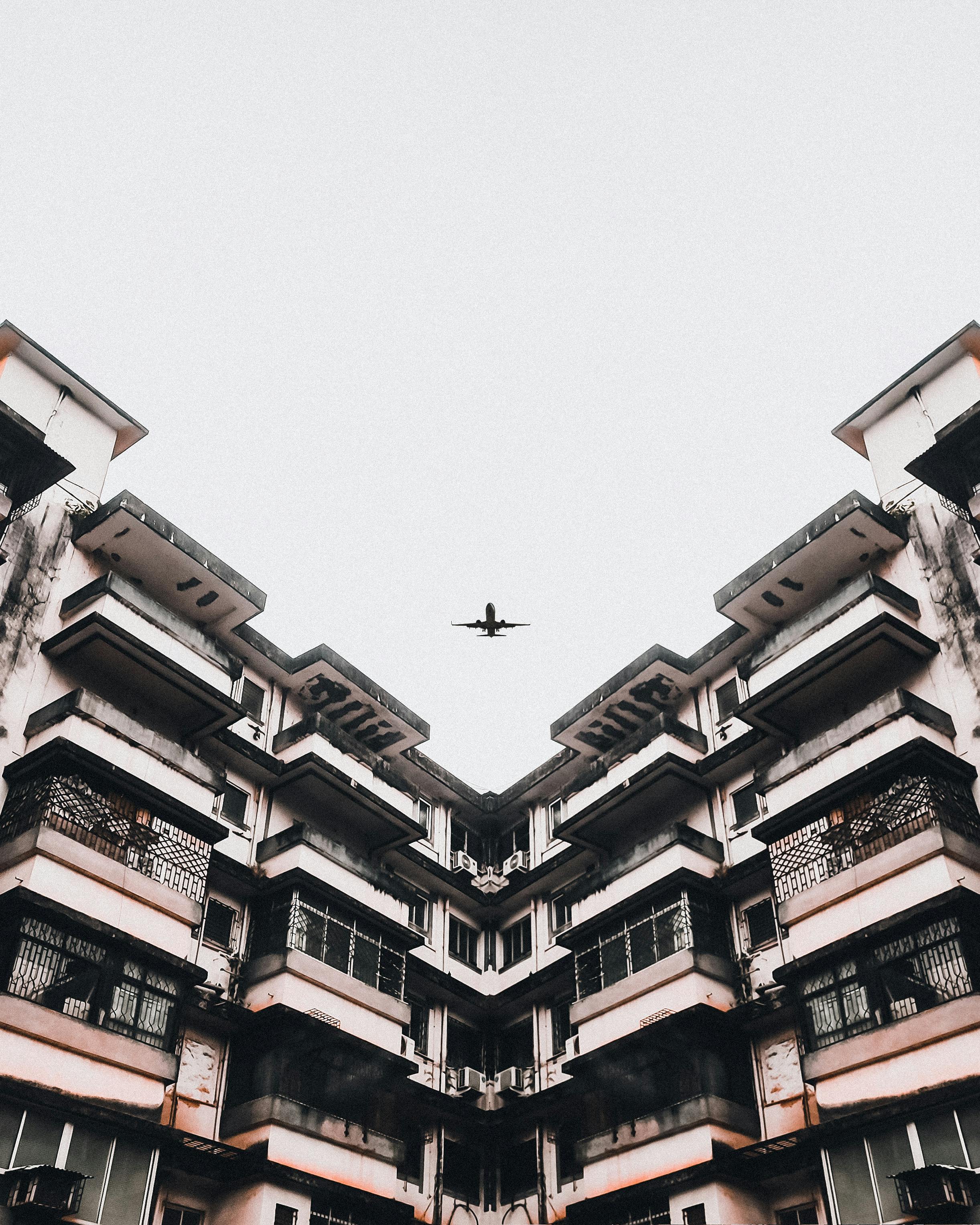 Airplane over Building · Free Stock Photo