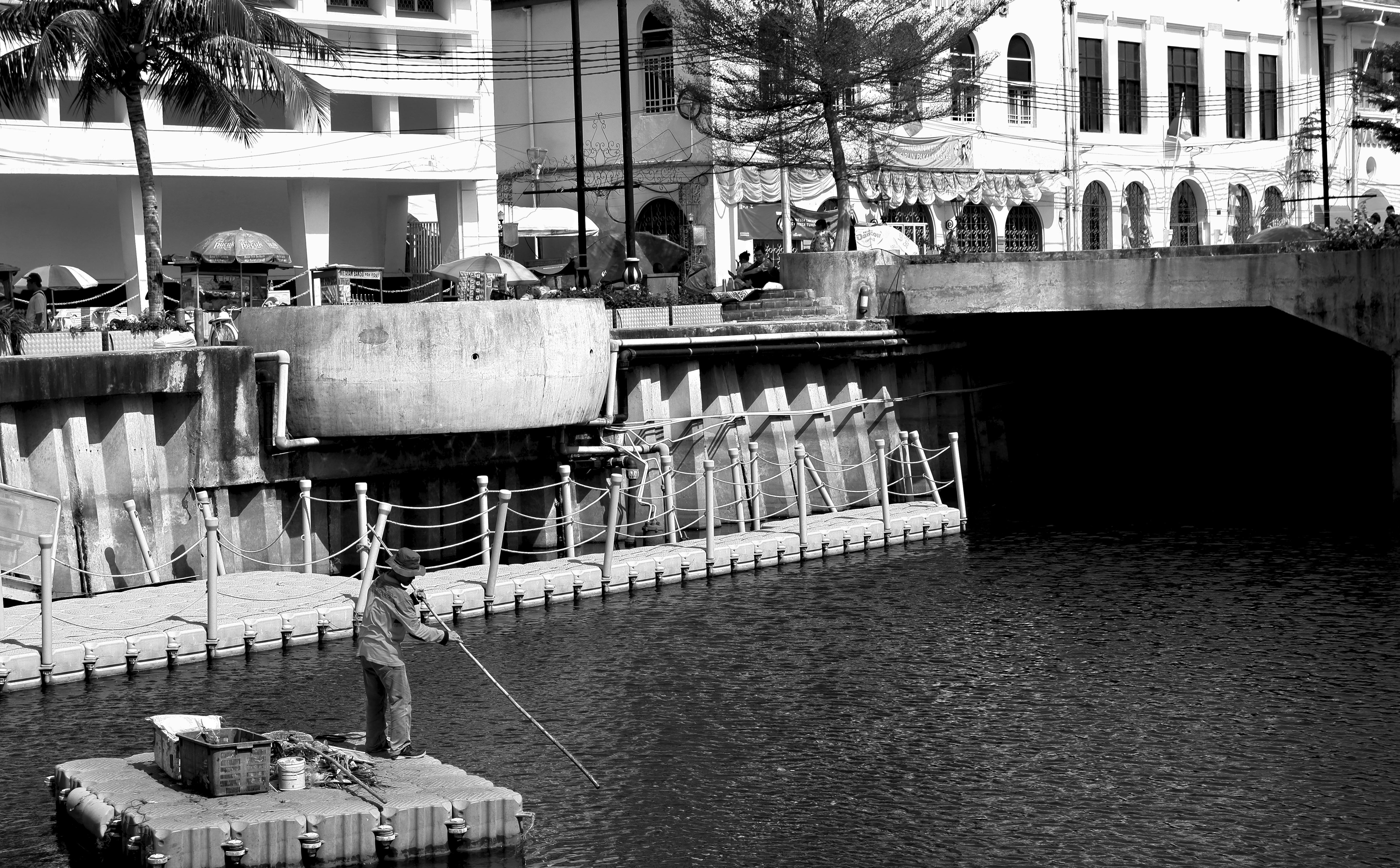 Grayscale Photo of Man Standing on Raft · Free Stock Photo