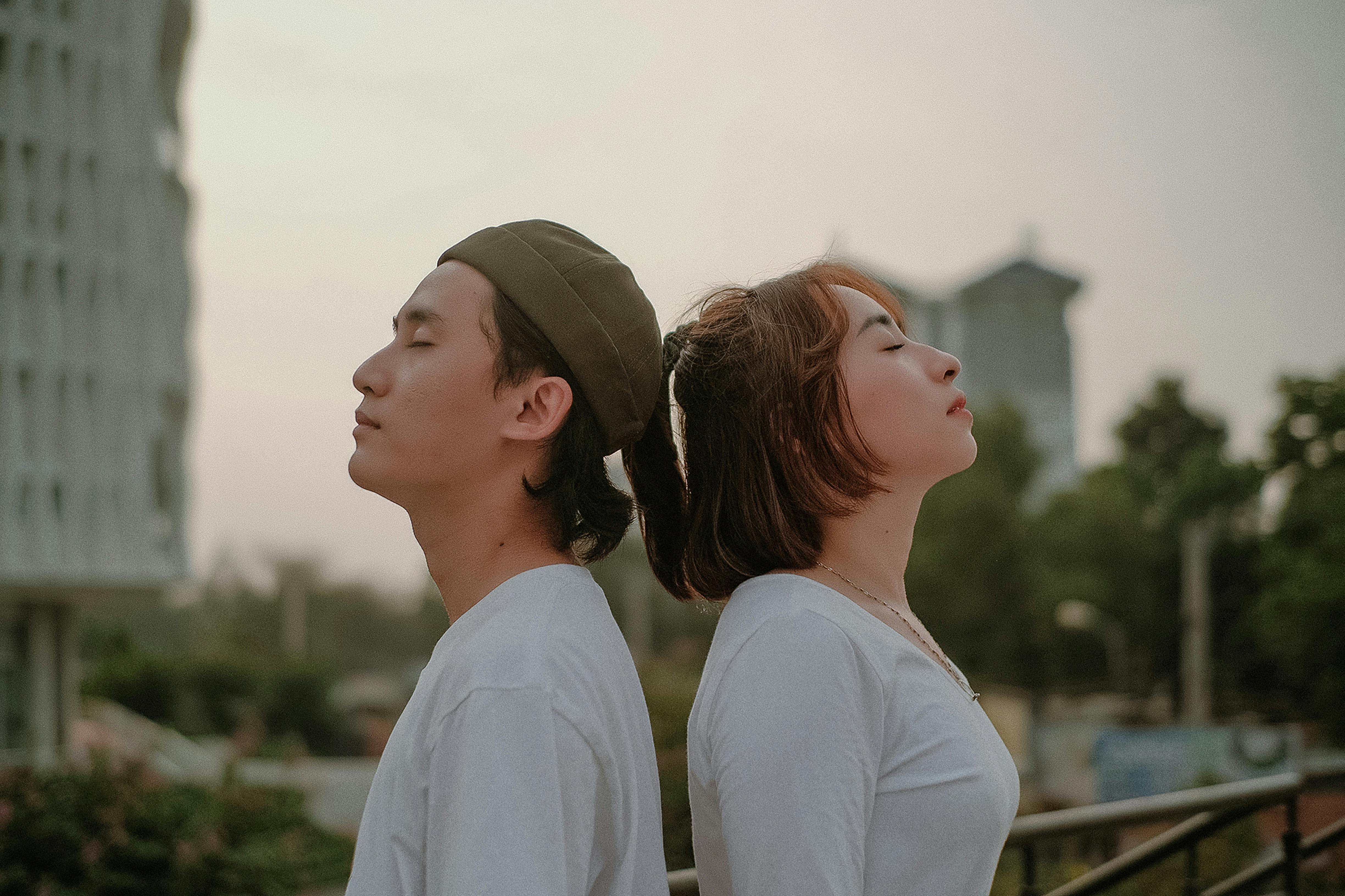 A Couple Standing Back to Back · Free Stock Photo