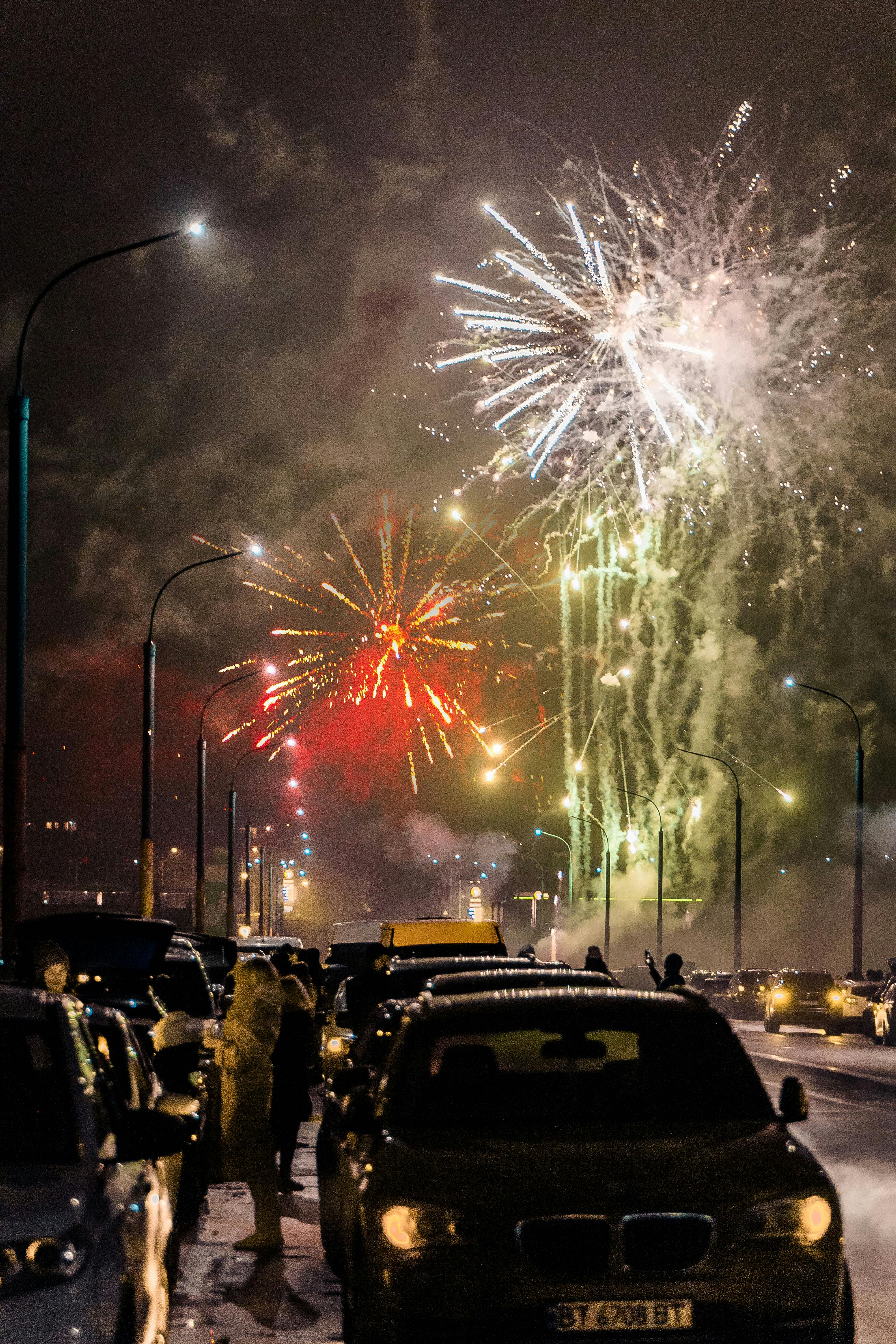 Cars Parked on the Street with Fireworks in the Sky at Night · Free ...