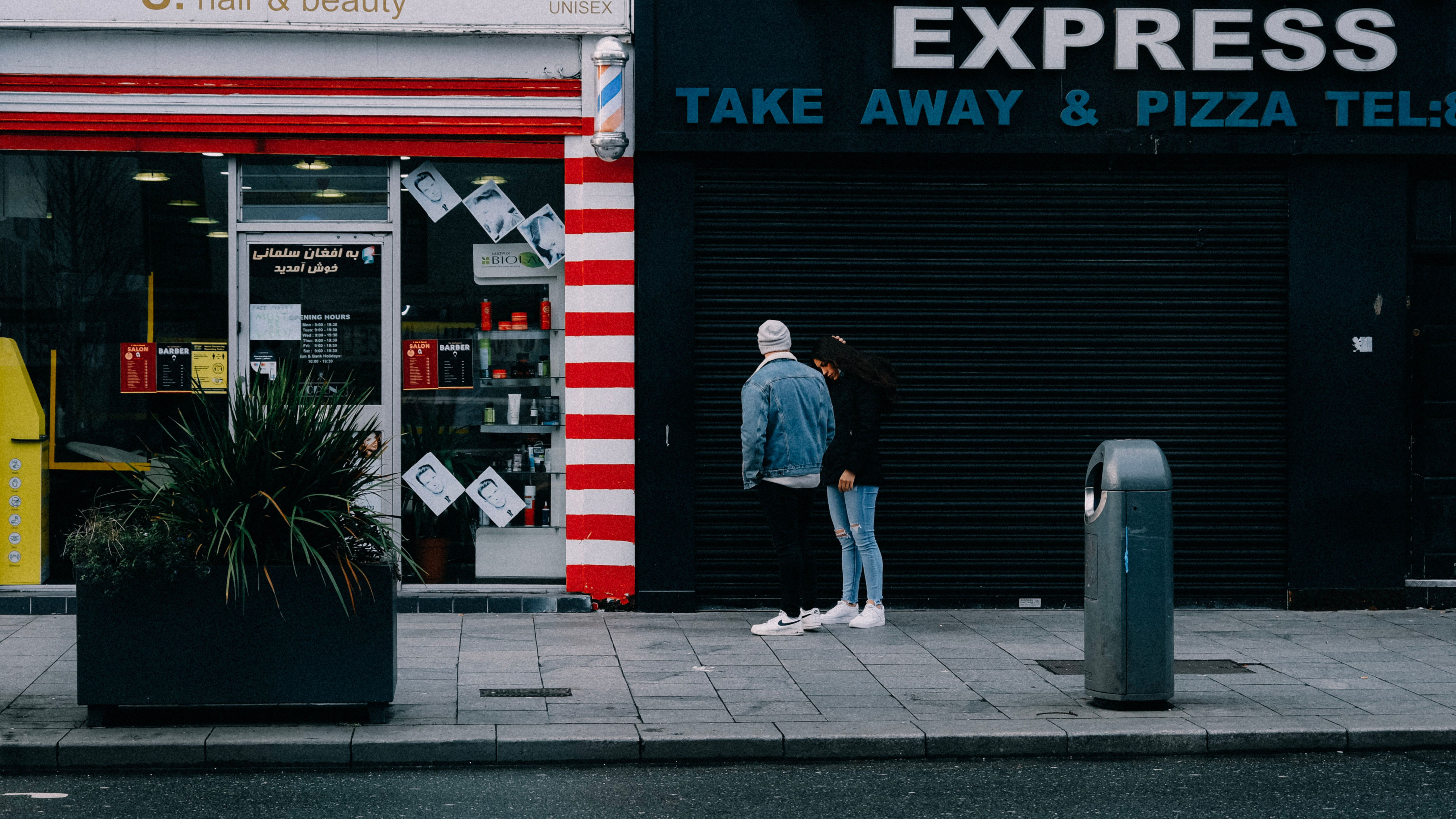 A Couple Walking on the Street while Having Conversation · Free Stock Photo