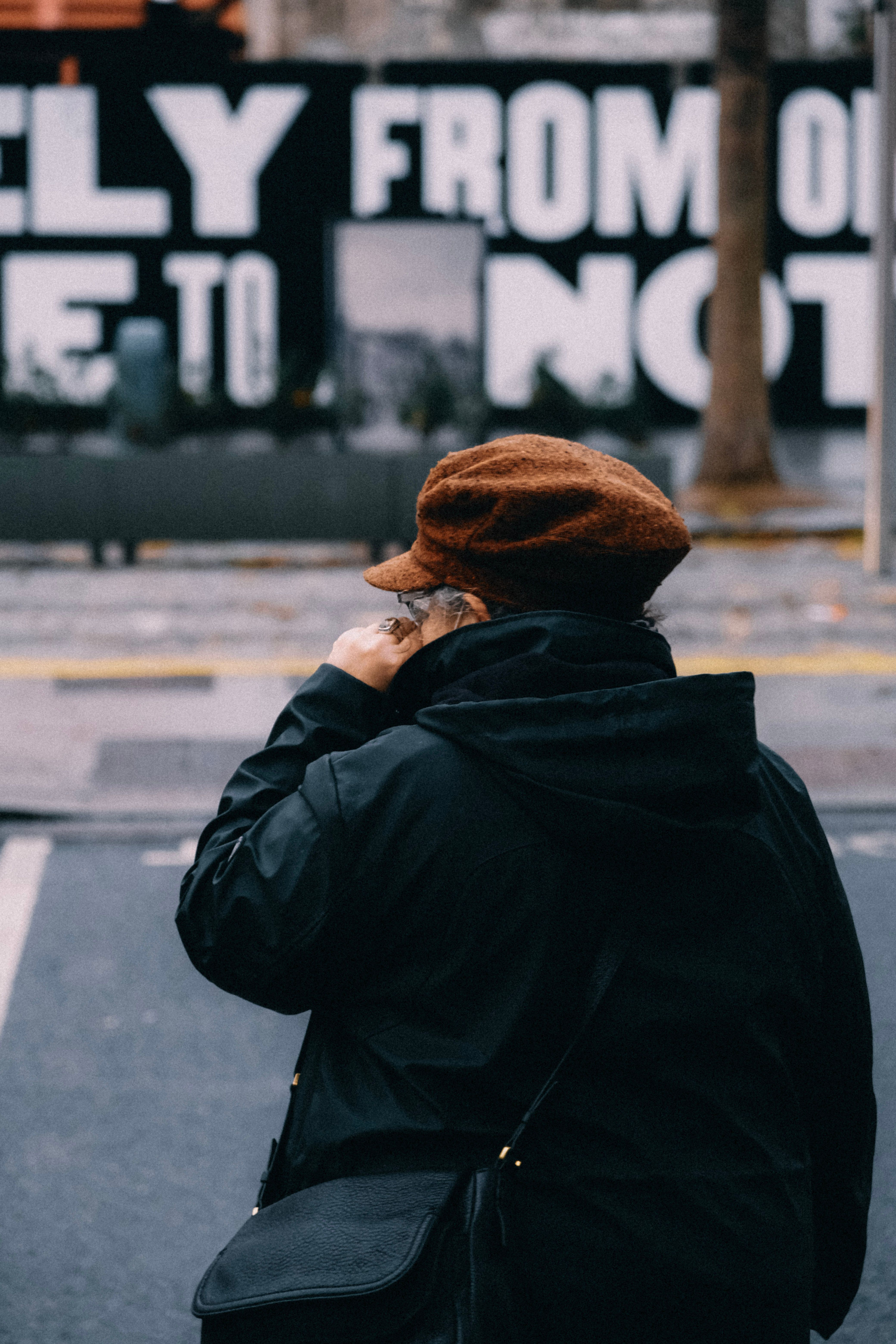 A Back View of a Person in Black Jacket while Wearing a Brown Cap ...