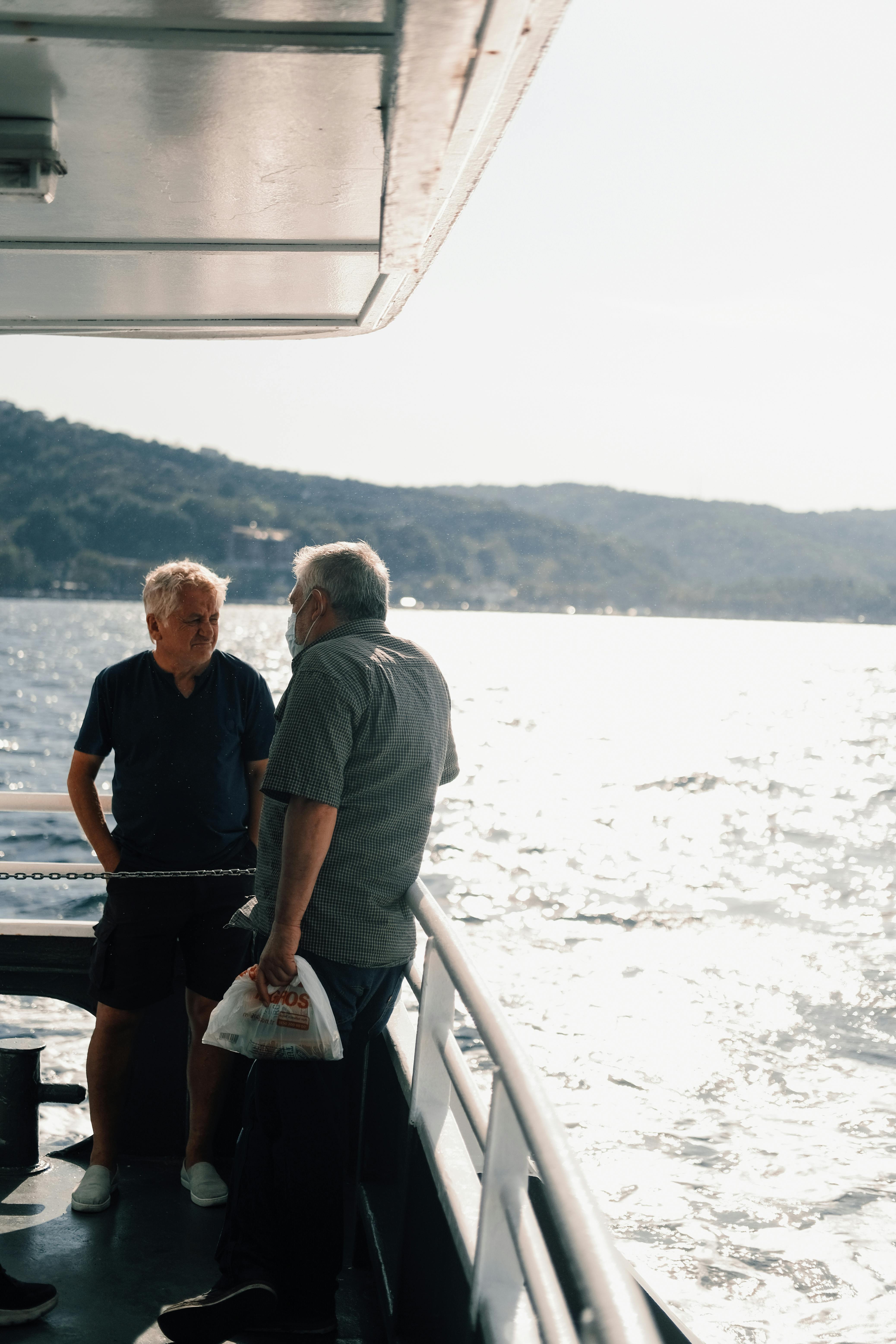 Gray Haired Men Leaning on Ship Railing · Free Stock Photo