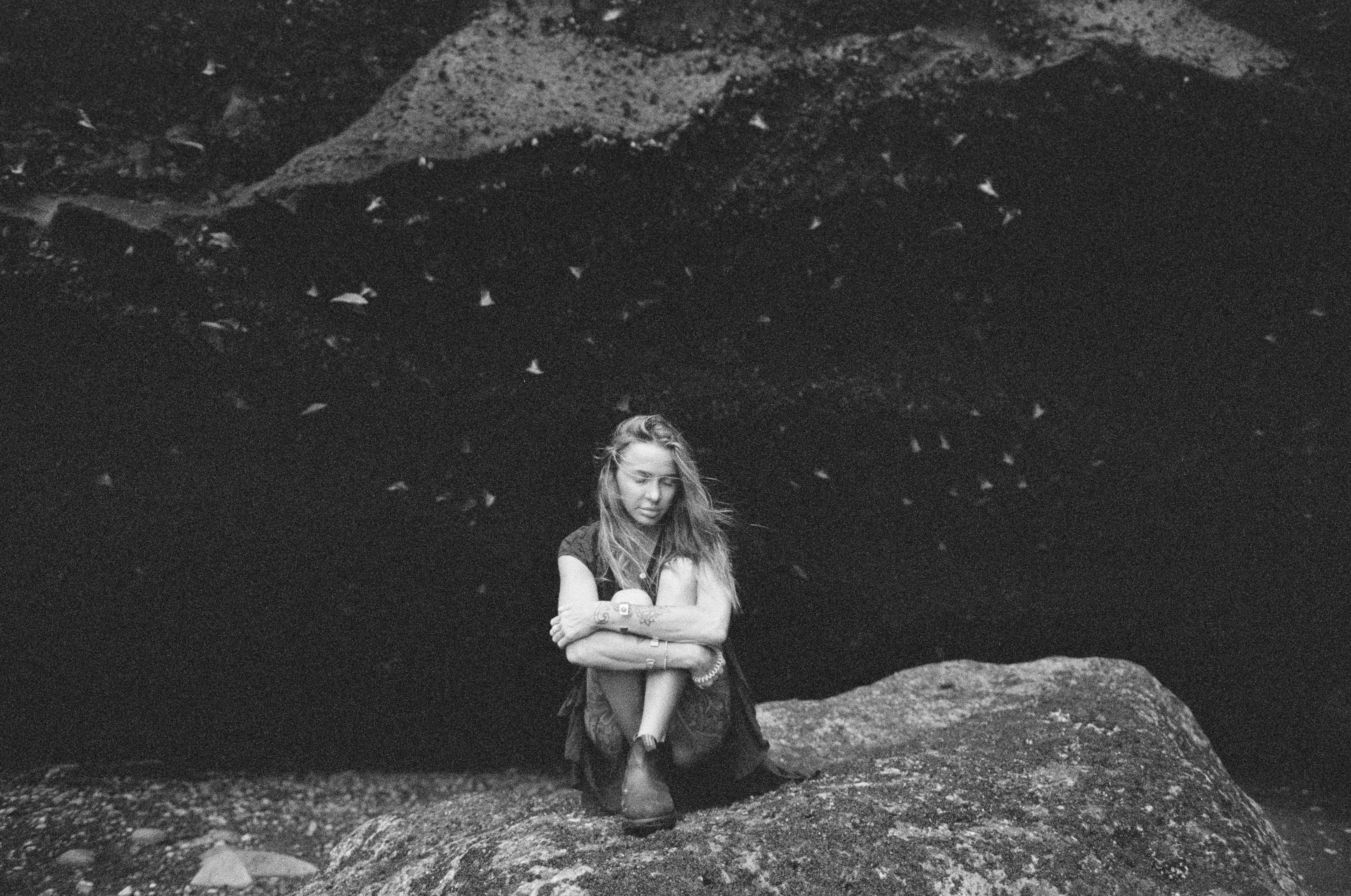 Woman Sitting on Rock with Her Eyes Closed Grayscale Photo · Free Stock ...