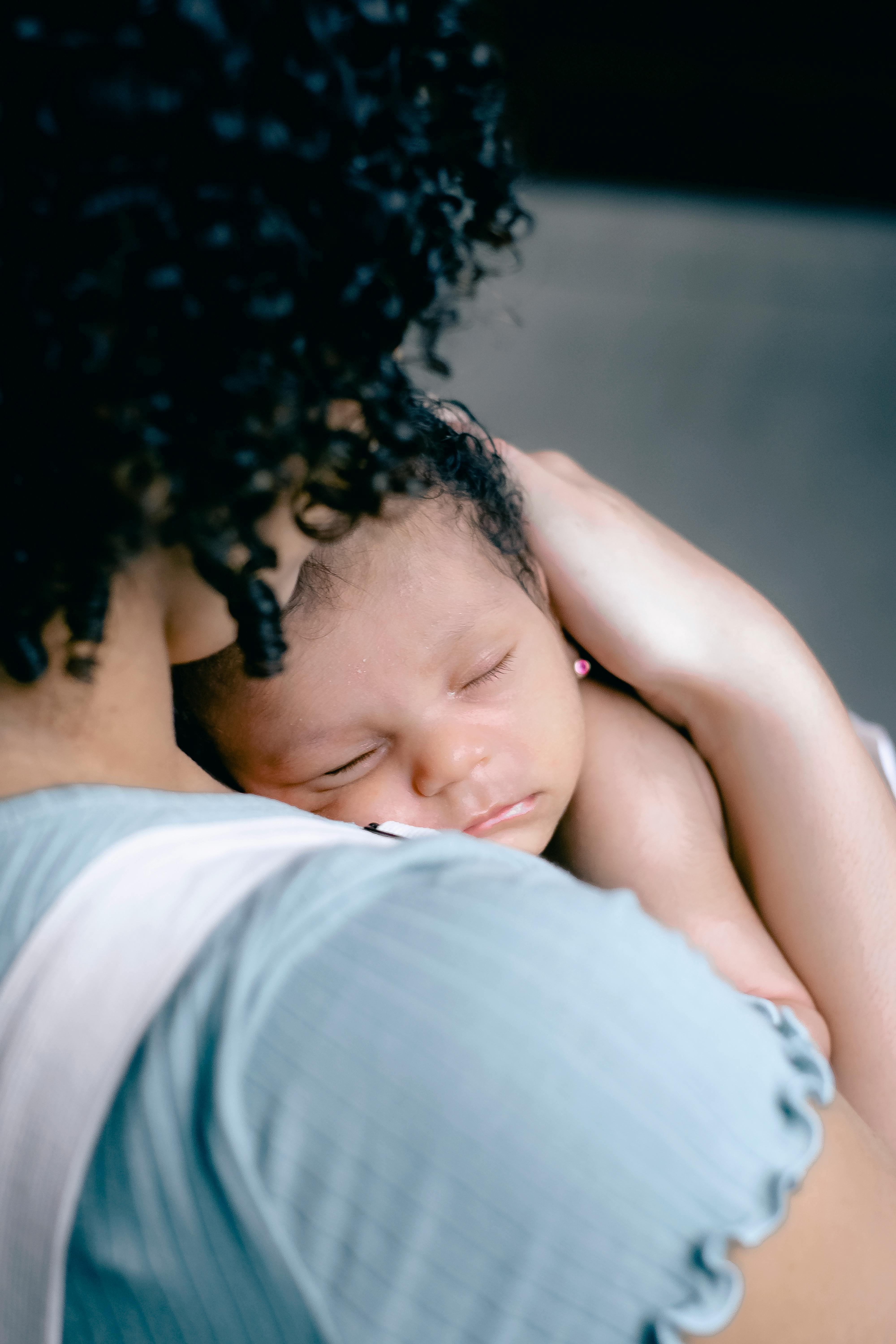 Woman Cuddling a Baby · Free Stock Photo