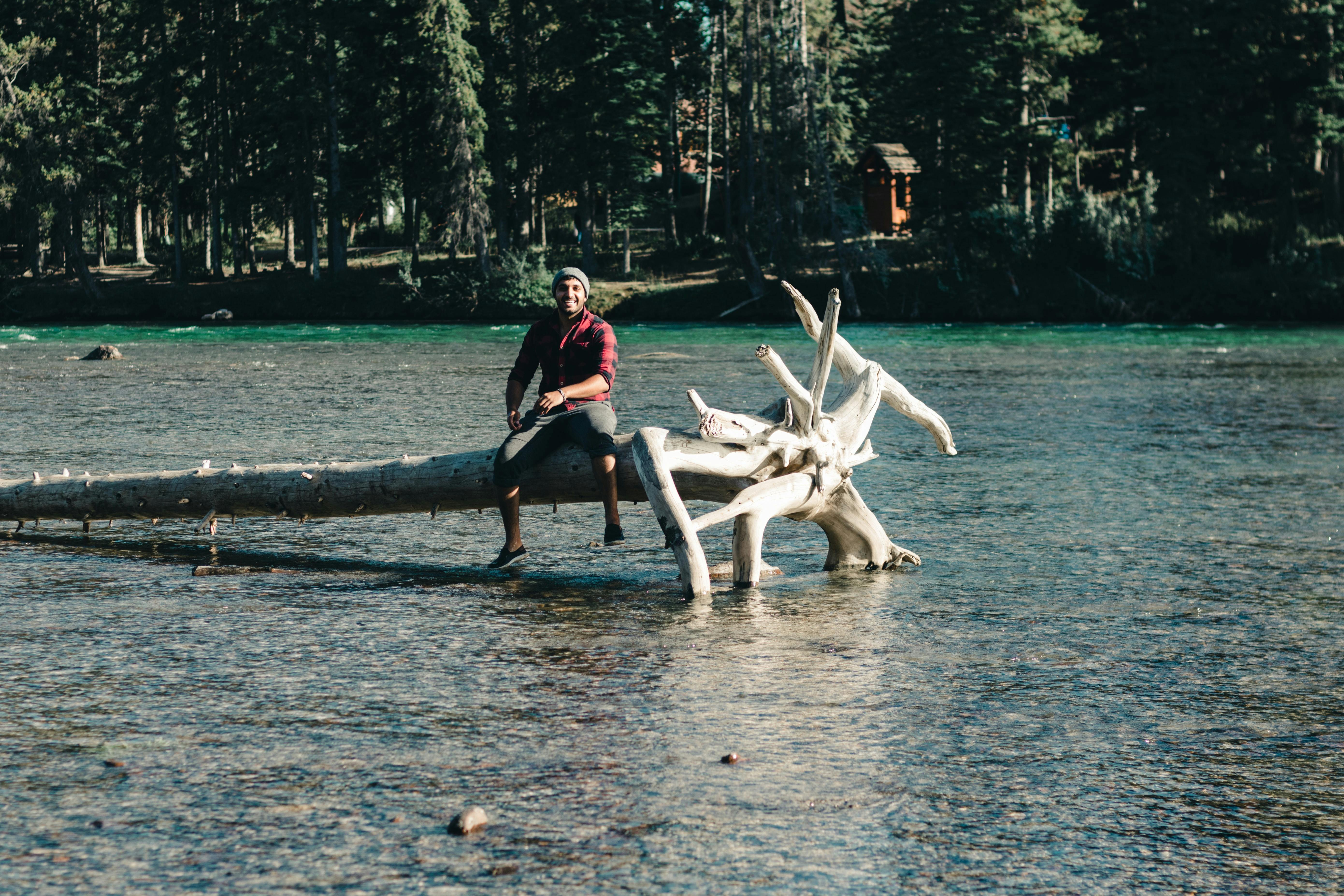 Man Sitting on Fallen Tree · Free Stock Photo