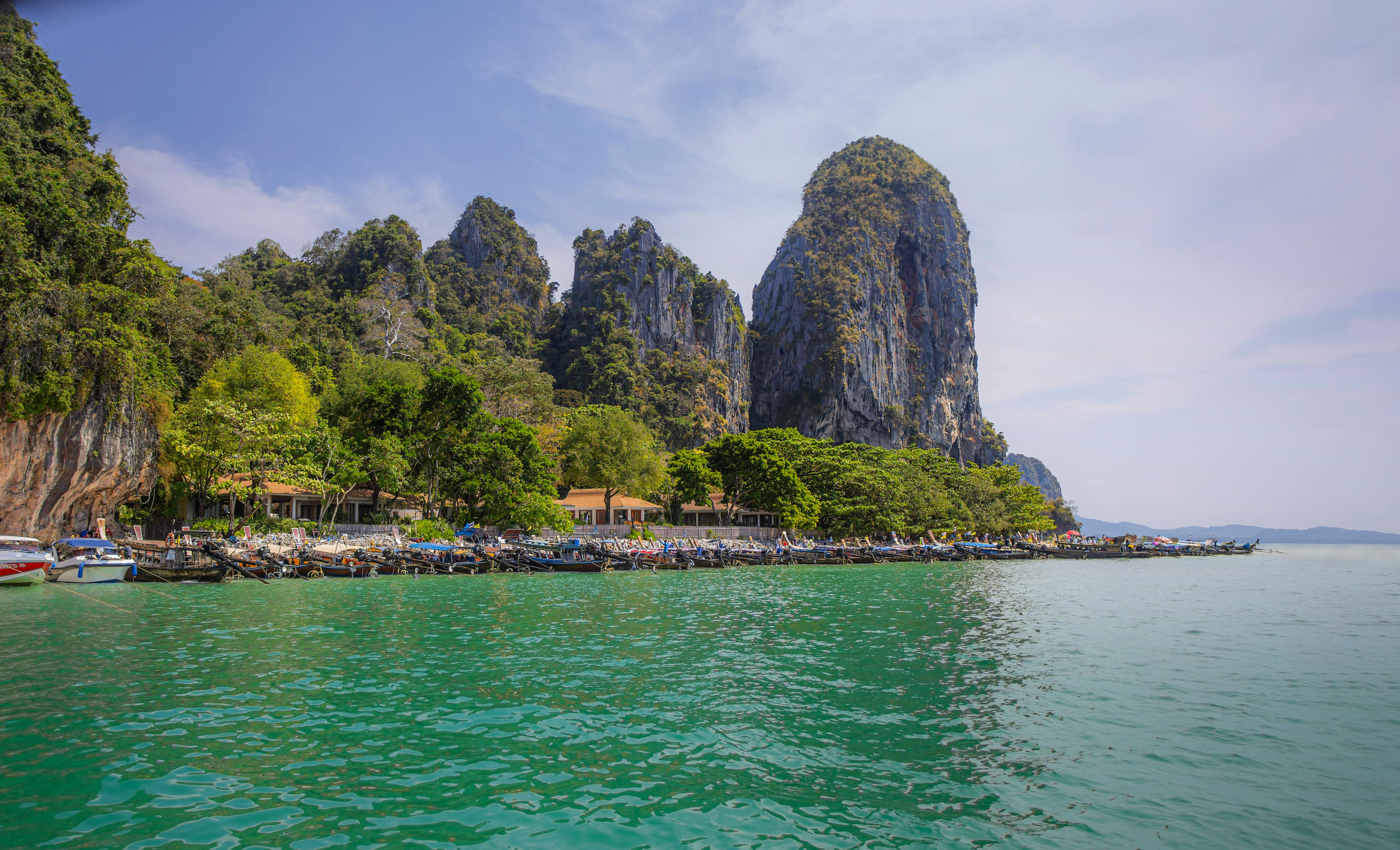 Boats Moored on the Coast Under Soaring Rocks · Free Stock Photo