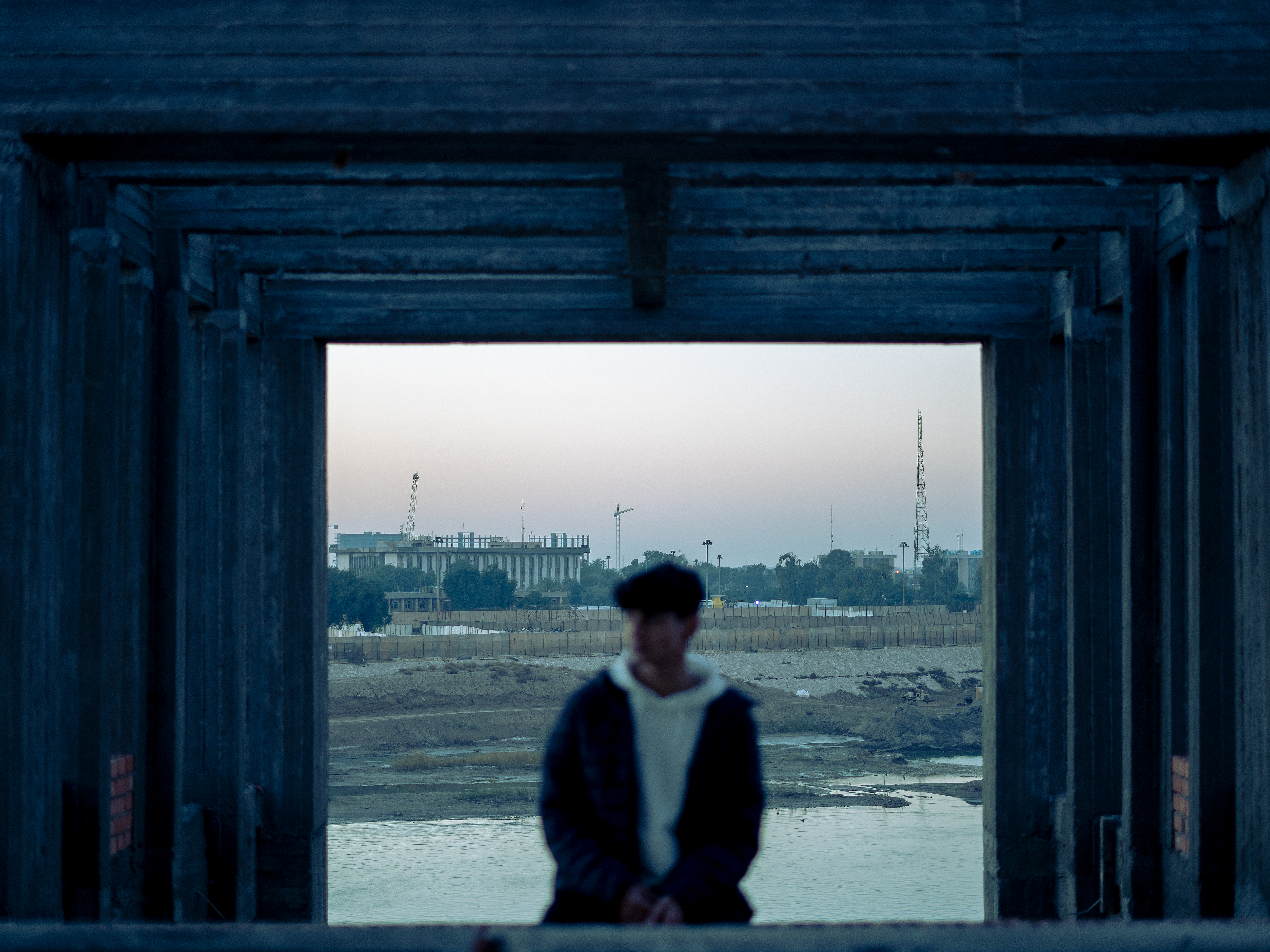 Man Standing Behind a Wooden Window Frame and Industrial Landscape in ...
