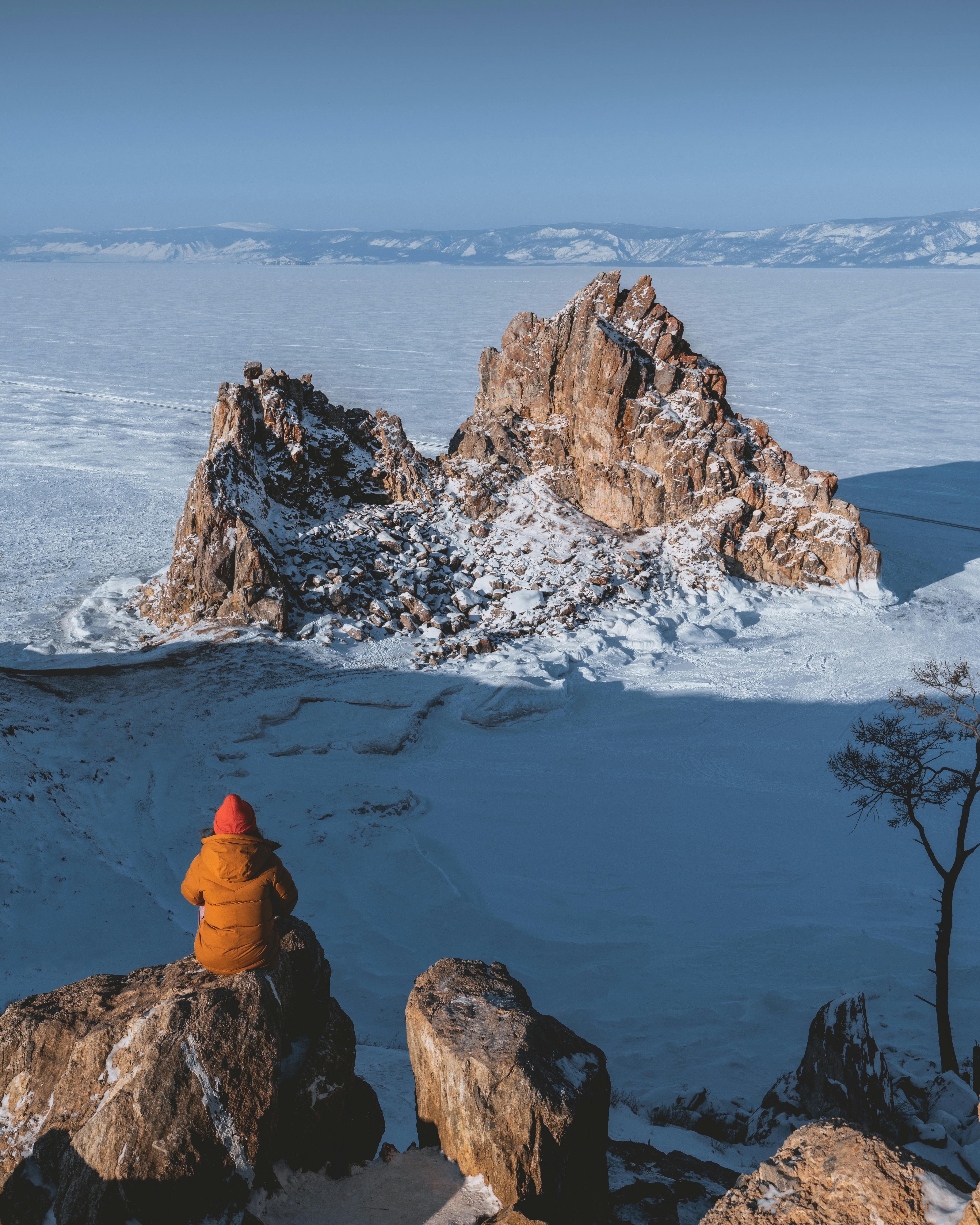 Person Looking at Rock Formation on Frozen Lake · Free Stock Photo