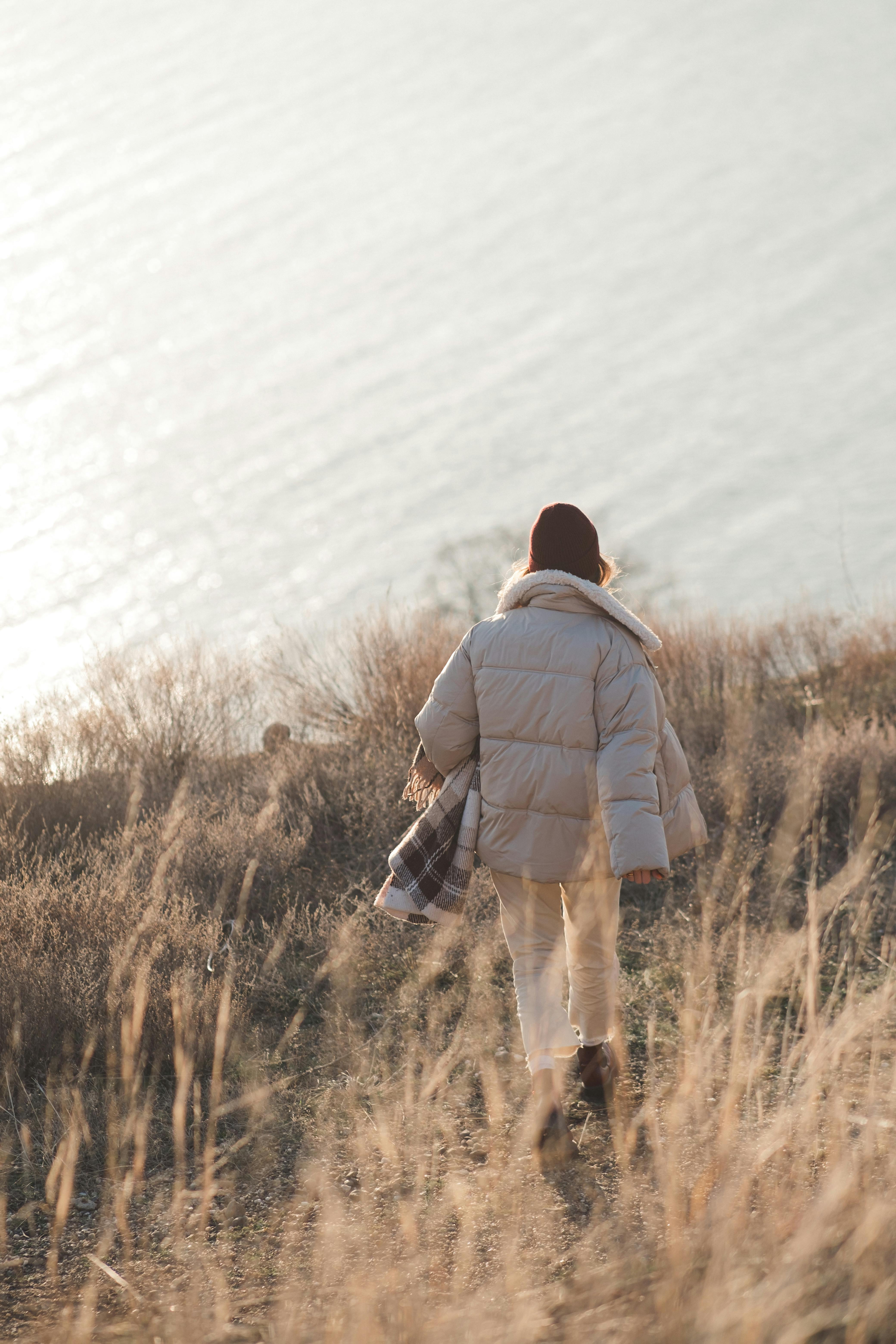 Person Walking on Grass Field · Free Stock Photo