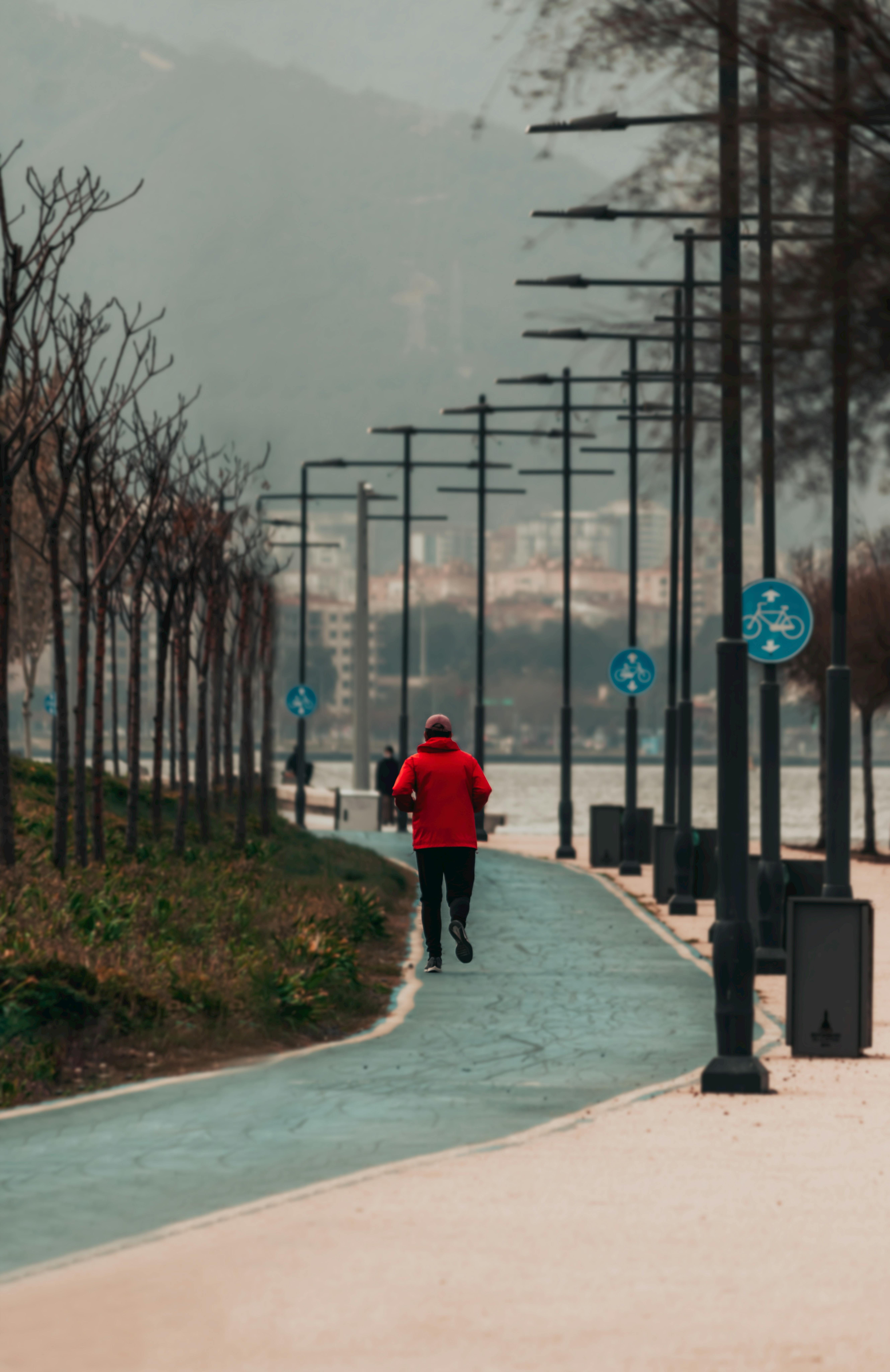 A Person in a Red Jacket Jogging at a Park · Free Stock Photo