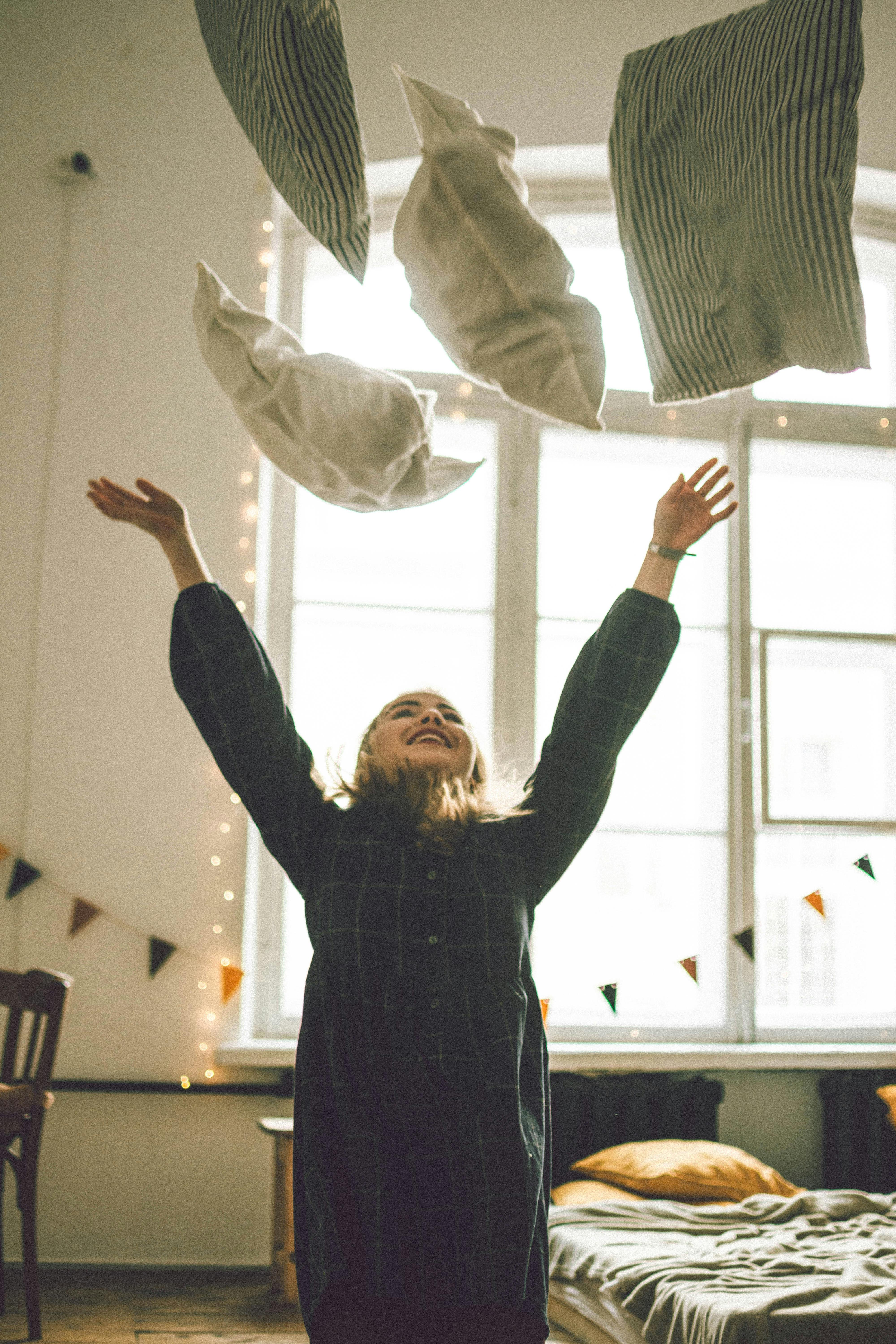 Happy Girl Throwing Pillows in Bedroom · Free Stock Photo