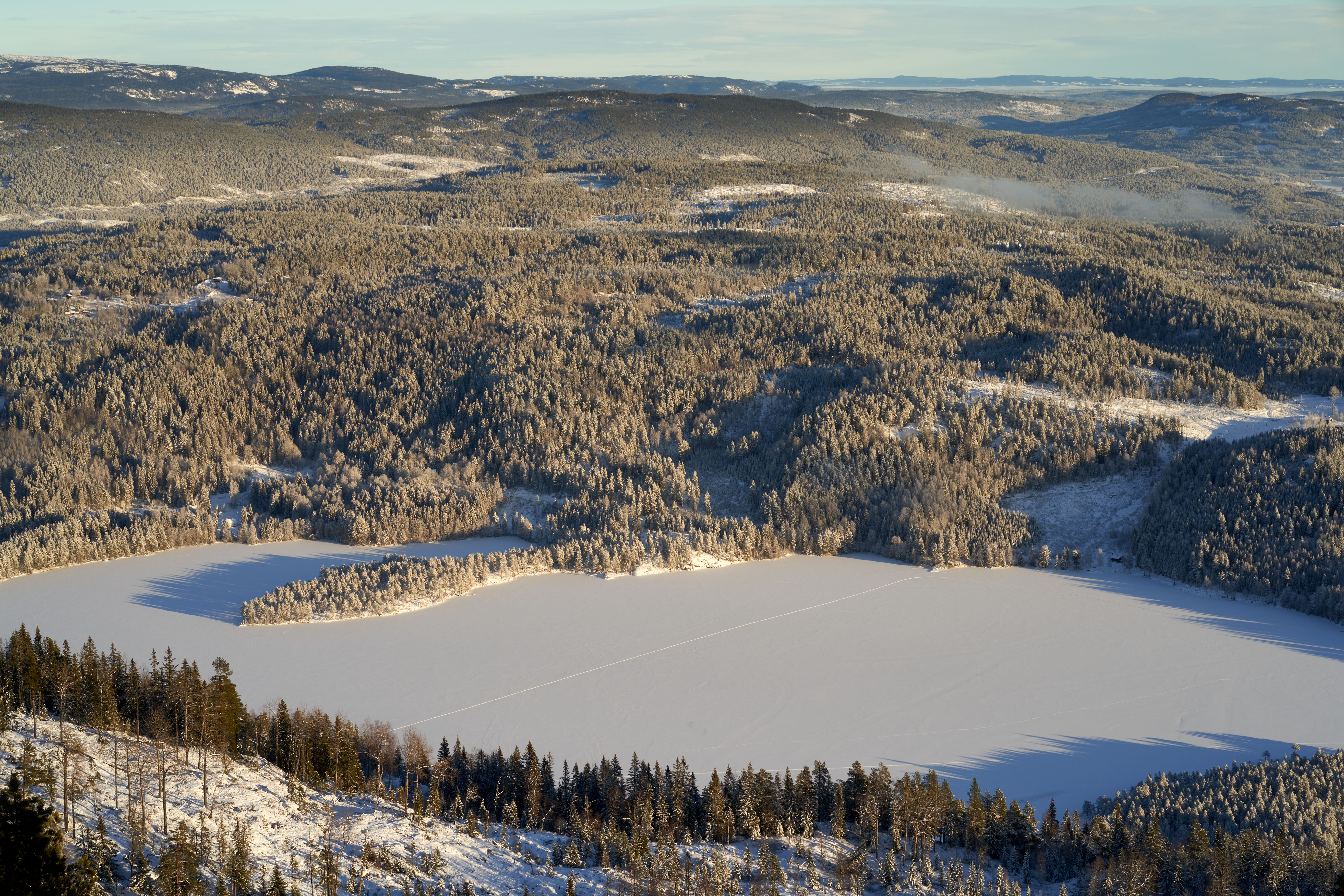 Aerial View of Frozen Lake Near Trees and Mountains · Free Stock Photo
