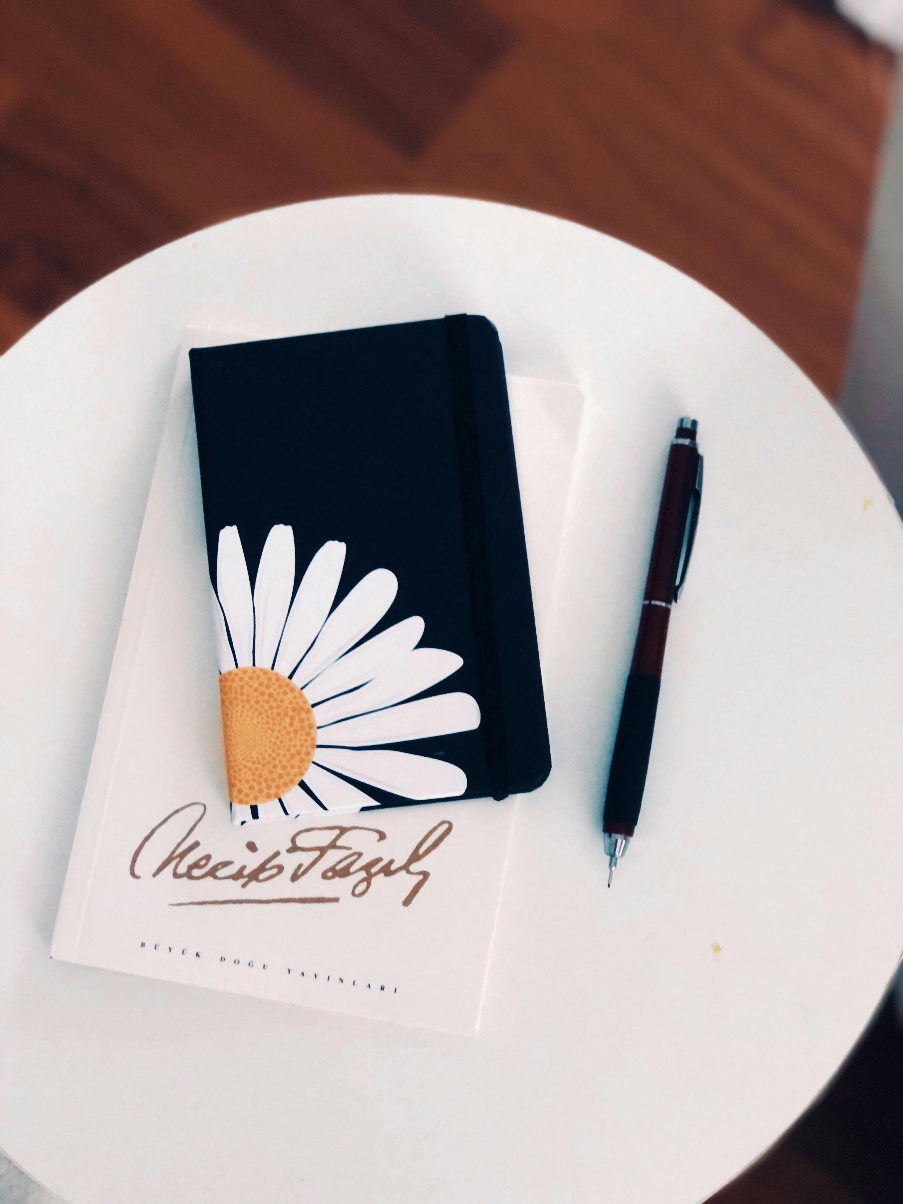 Notebooks and a Pen on a Table · Free Stock Photo