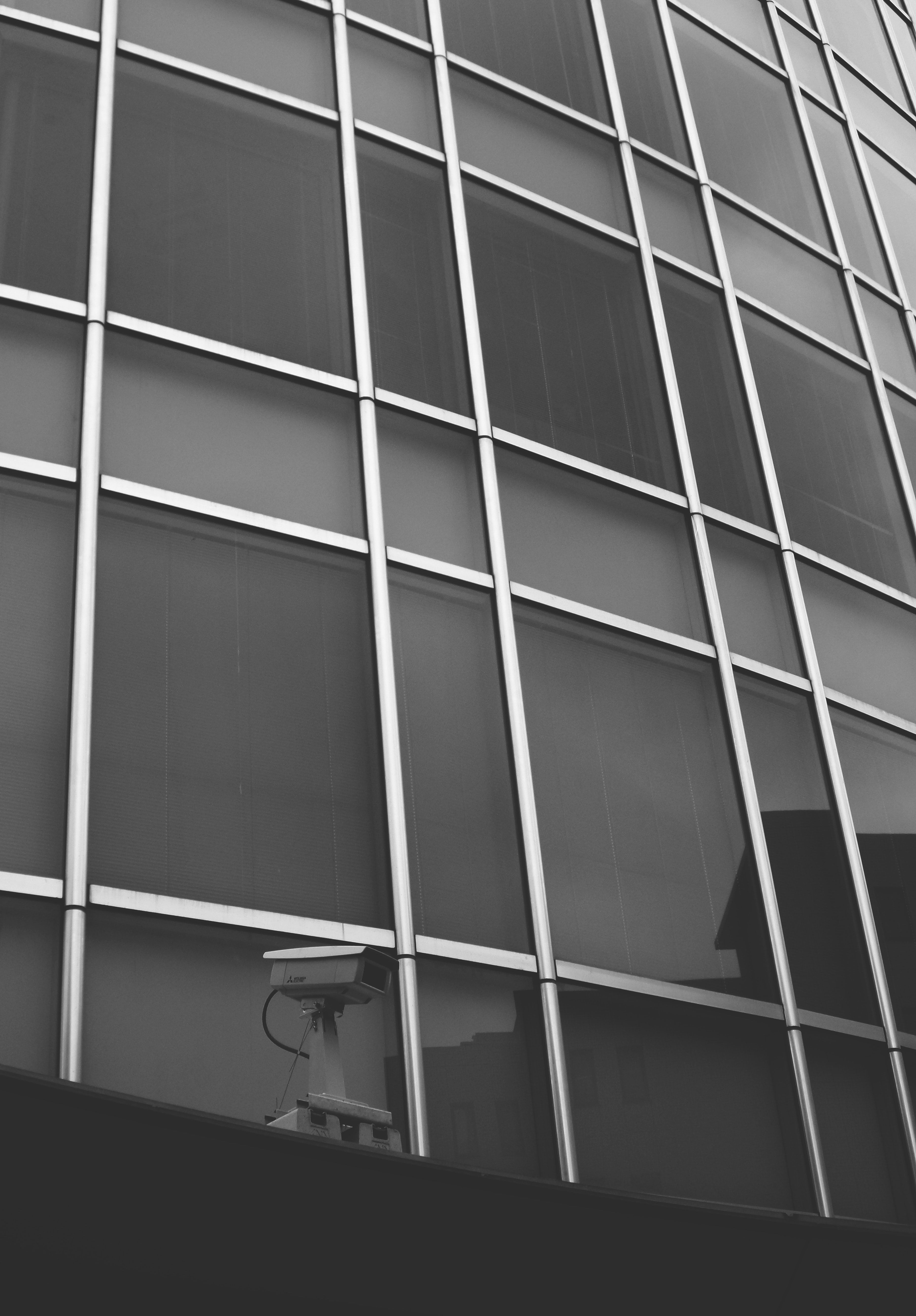 Grayscale Photo of Glass Windows of a Building · Free Stock Photo