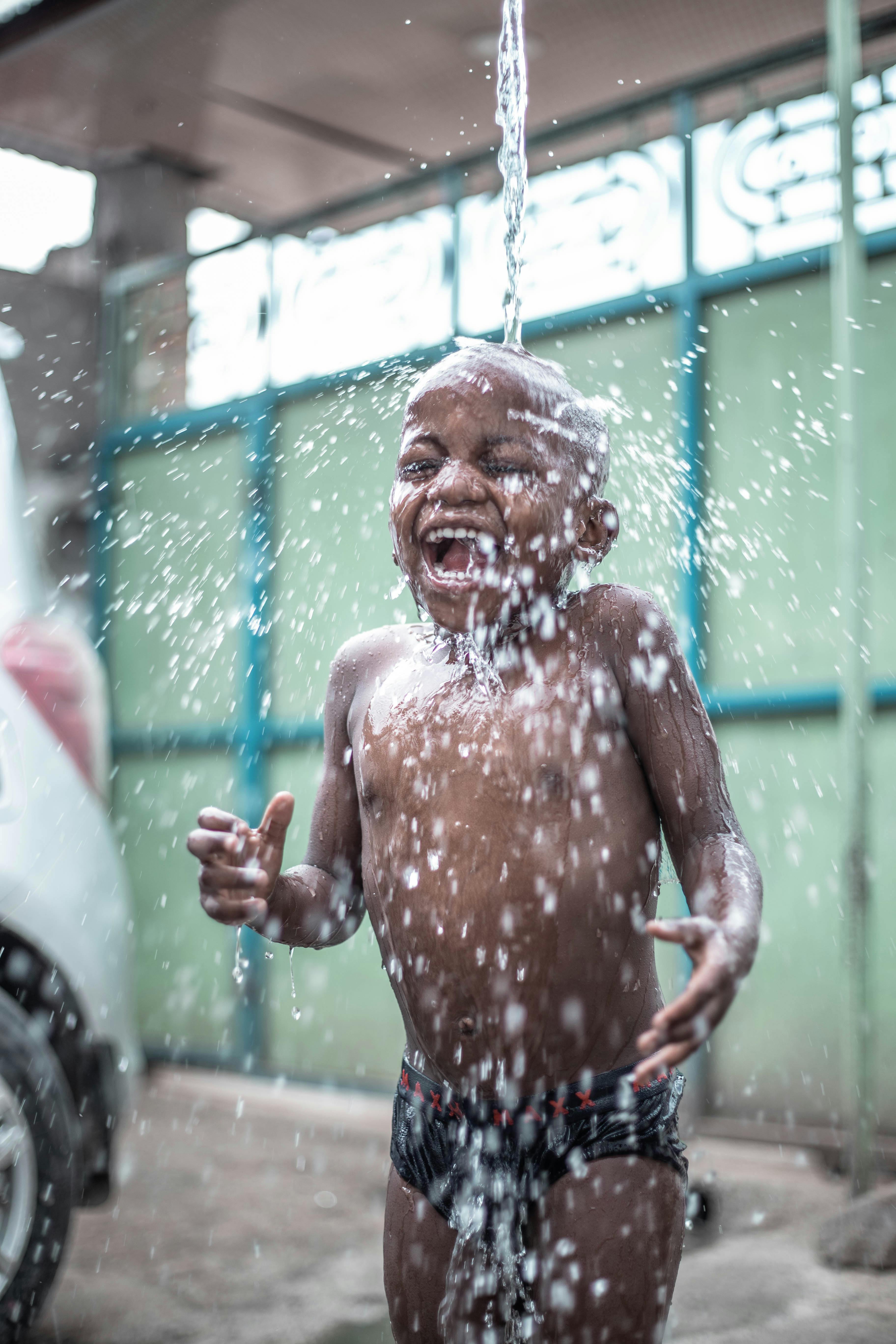 A Boy Getting Splashed with Water · Free Stock Photo
