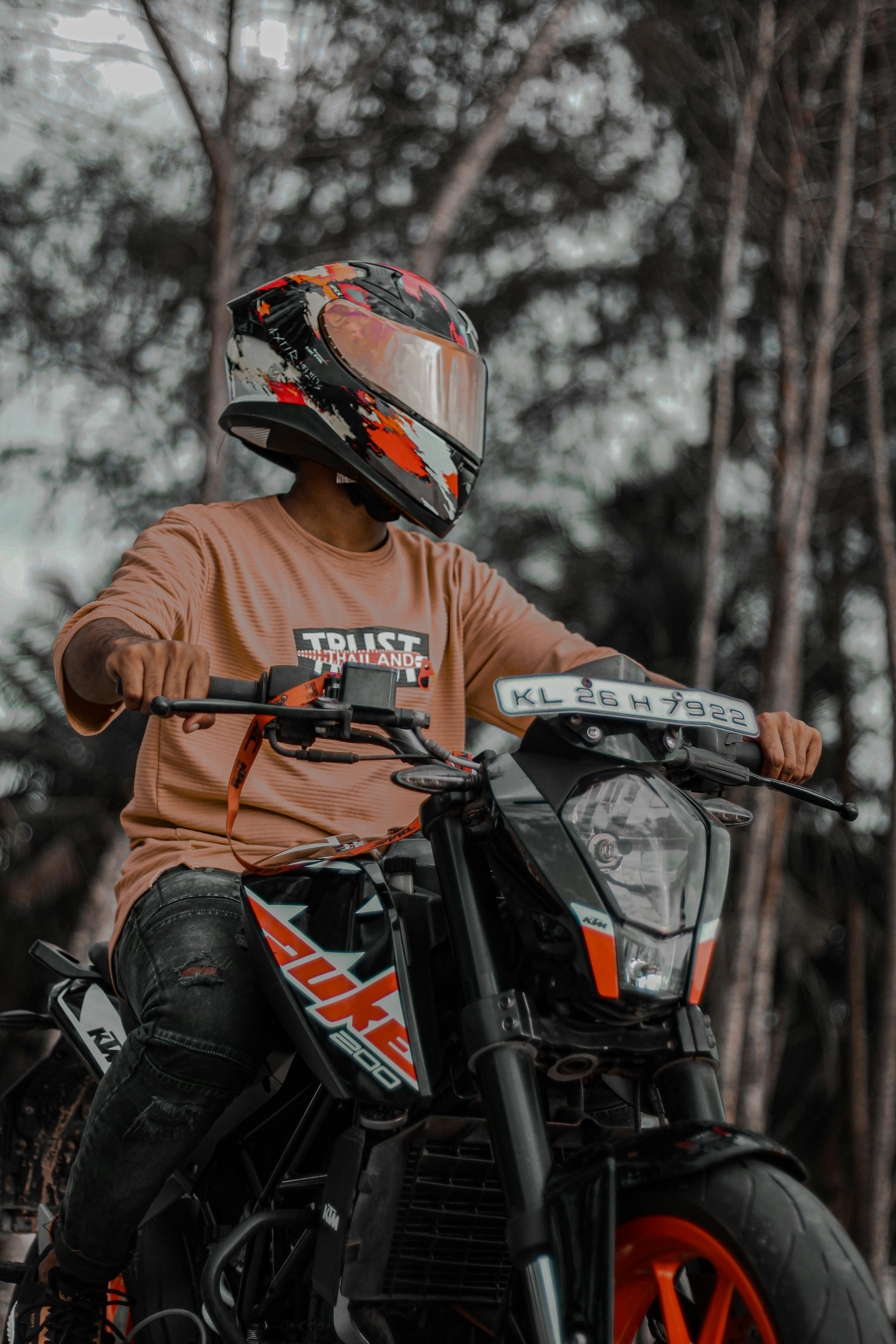 A Man Wearing a Helmet Riding a Motorcycle · Free Stock Photo