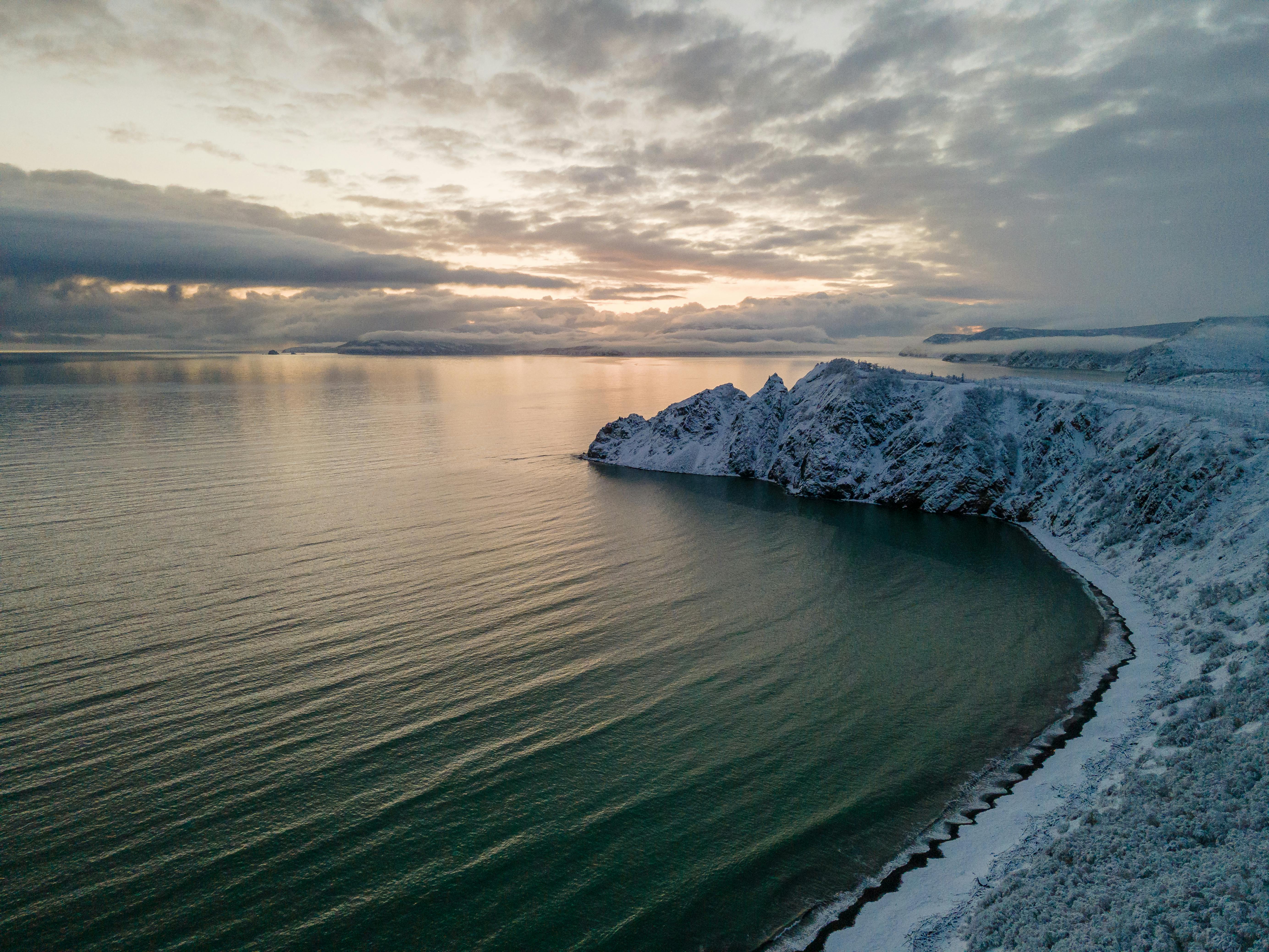 Snow Covered Seashore Under a Cloudy Sky · Free Stock Photo