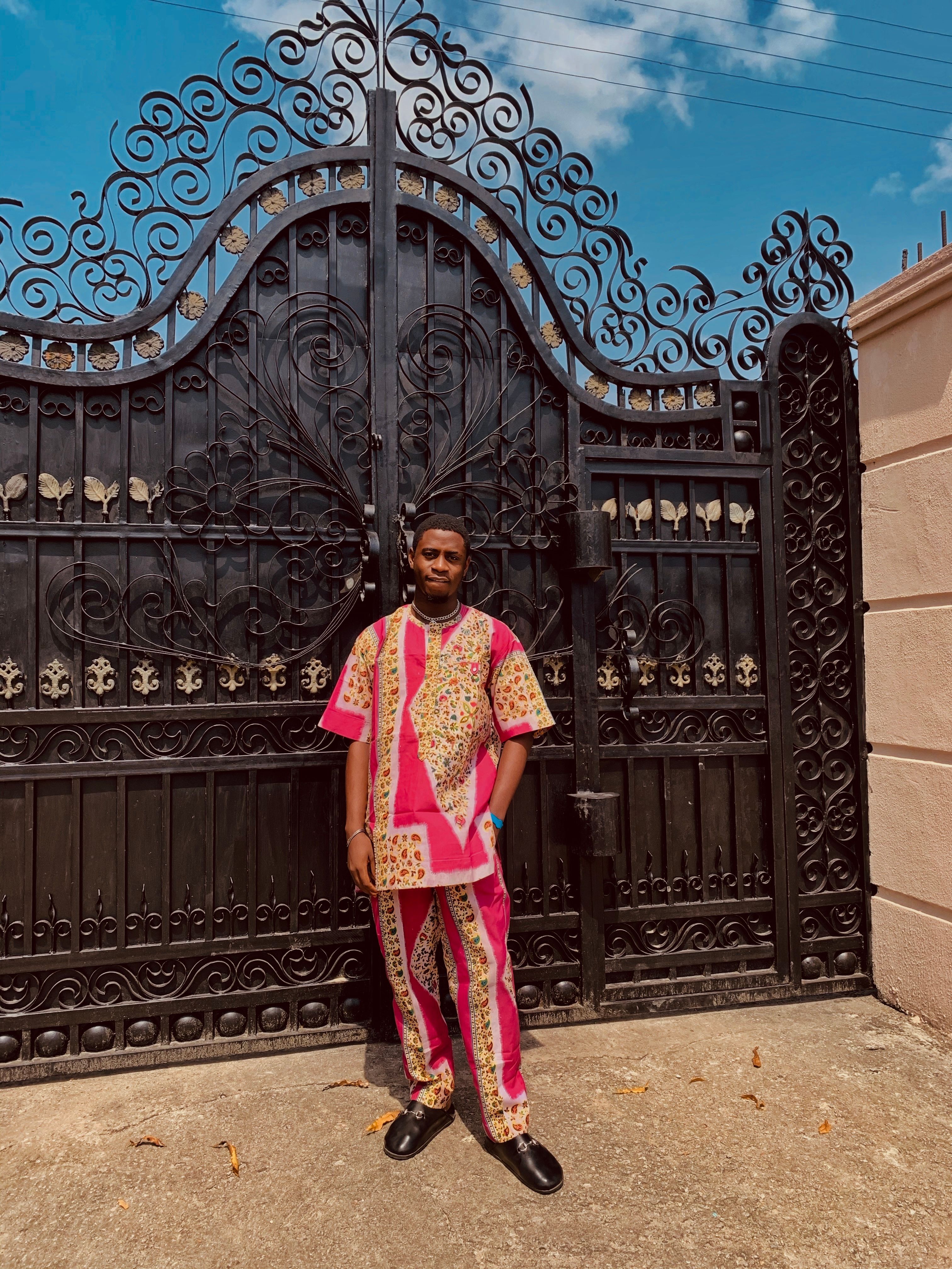 Man Standing Beside a Metal Gate · Free Stock Photo
