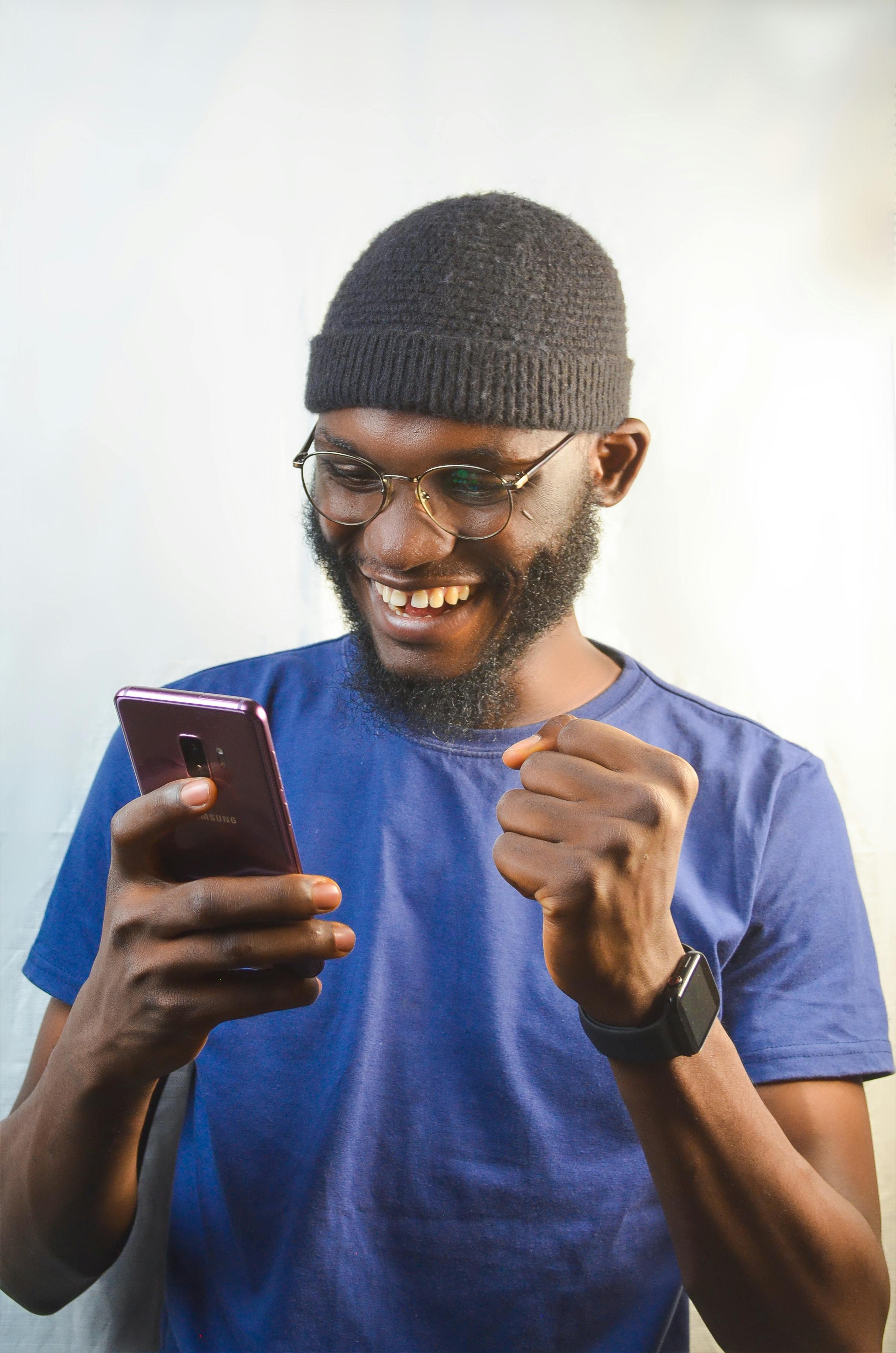 A Happy Man Looking at a Cellphone · Free Stock Photo