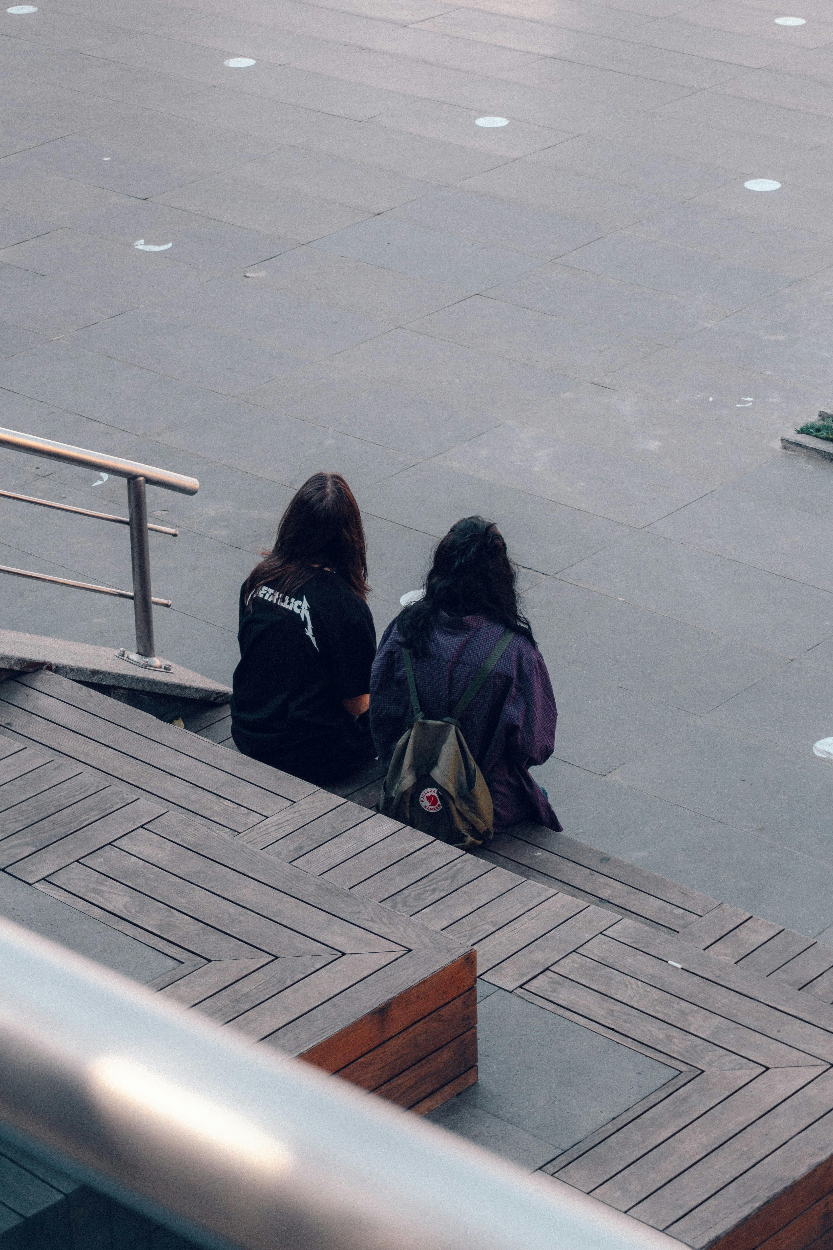 Women Sitting Back to Back · Free Stock Photo