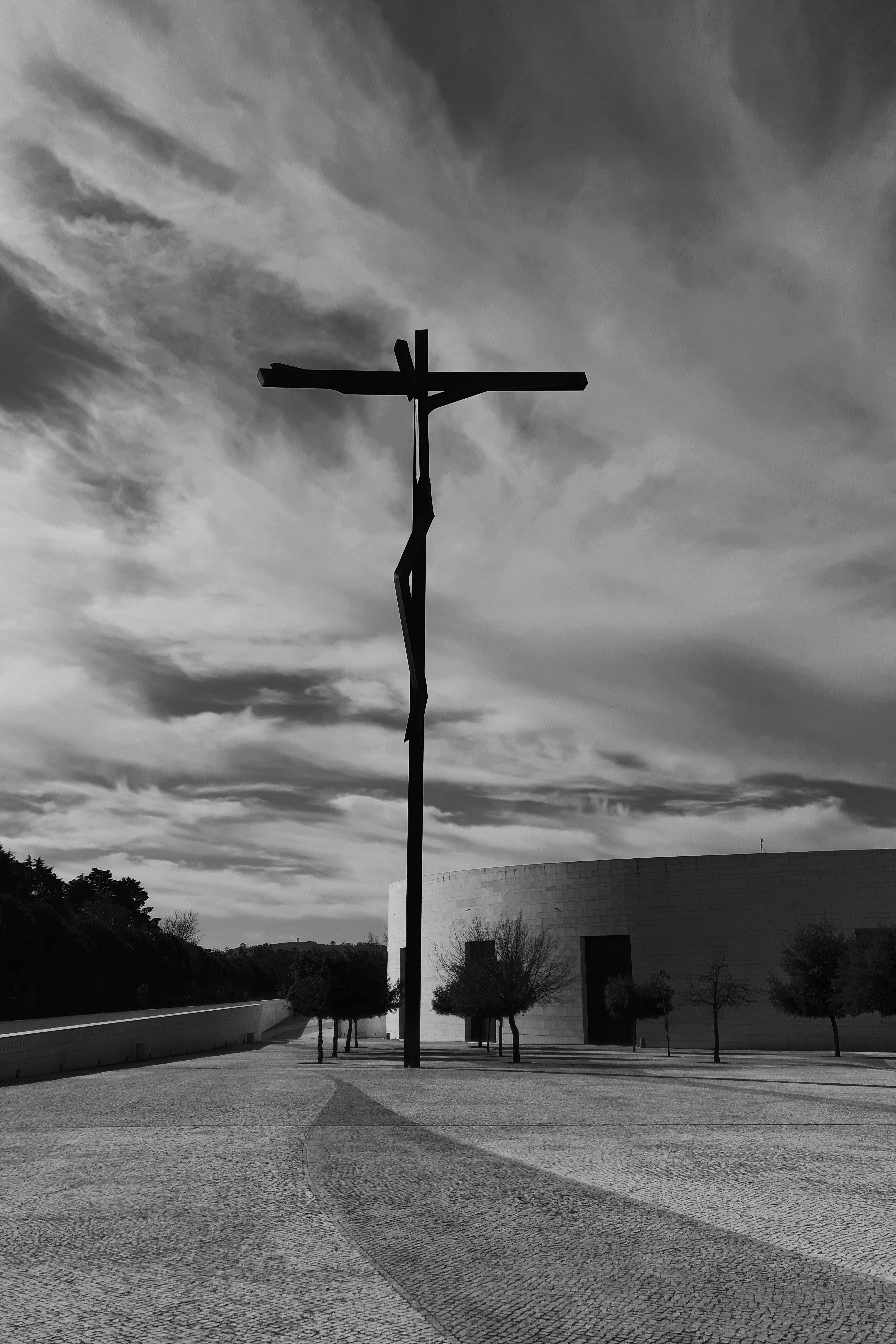 A Statue of a Person Carrying a Cross · Free Stock Photo