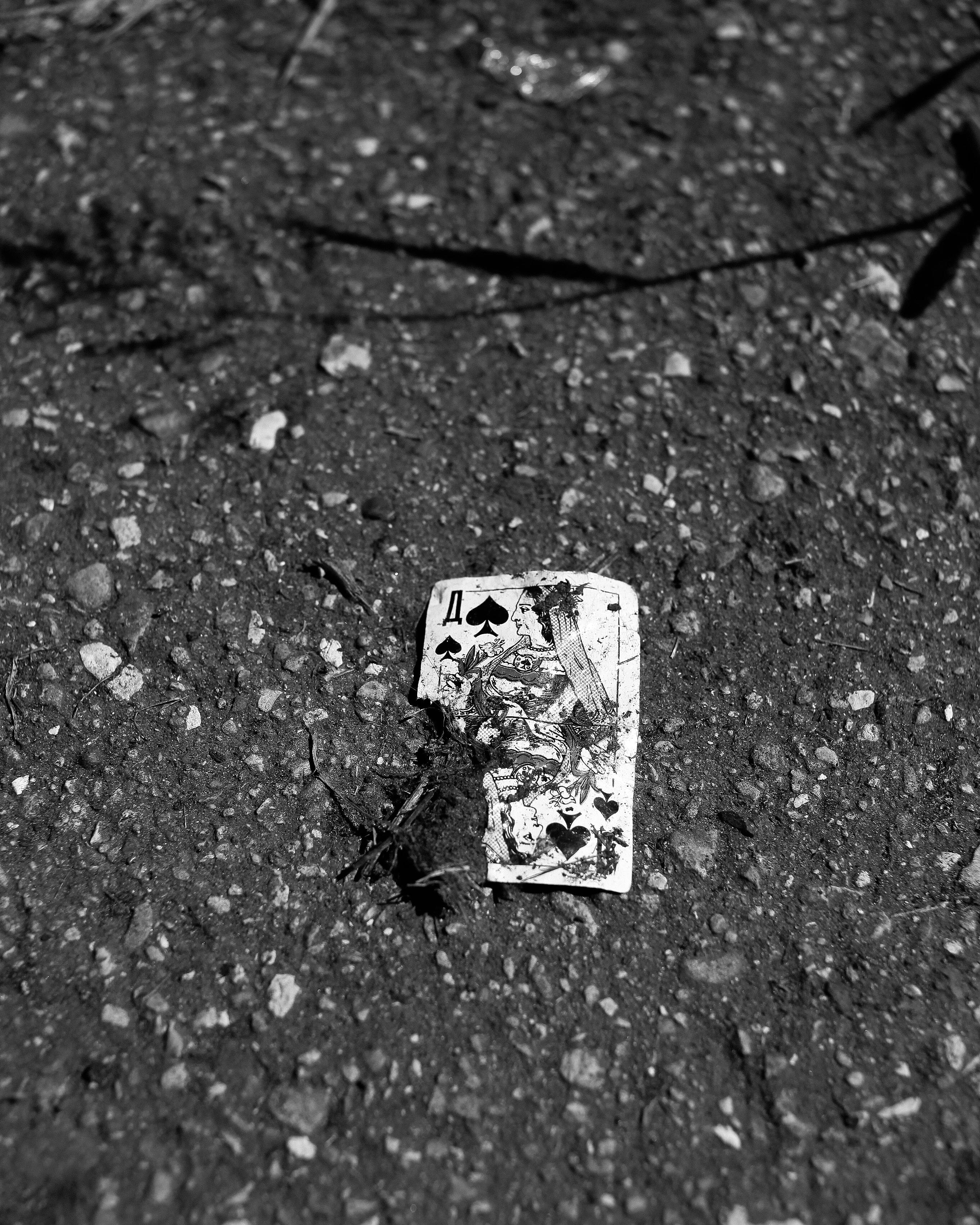 Grayscale Photo of a Broken Poker Card on the Ground · Free Stock Photo