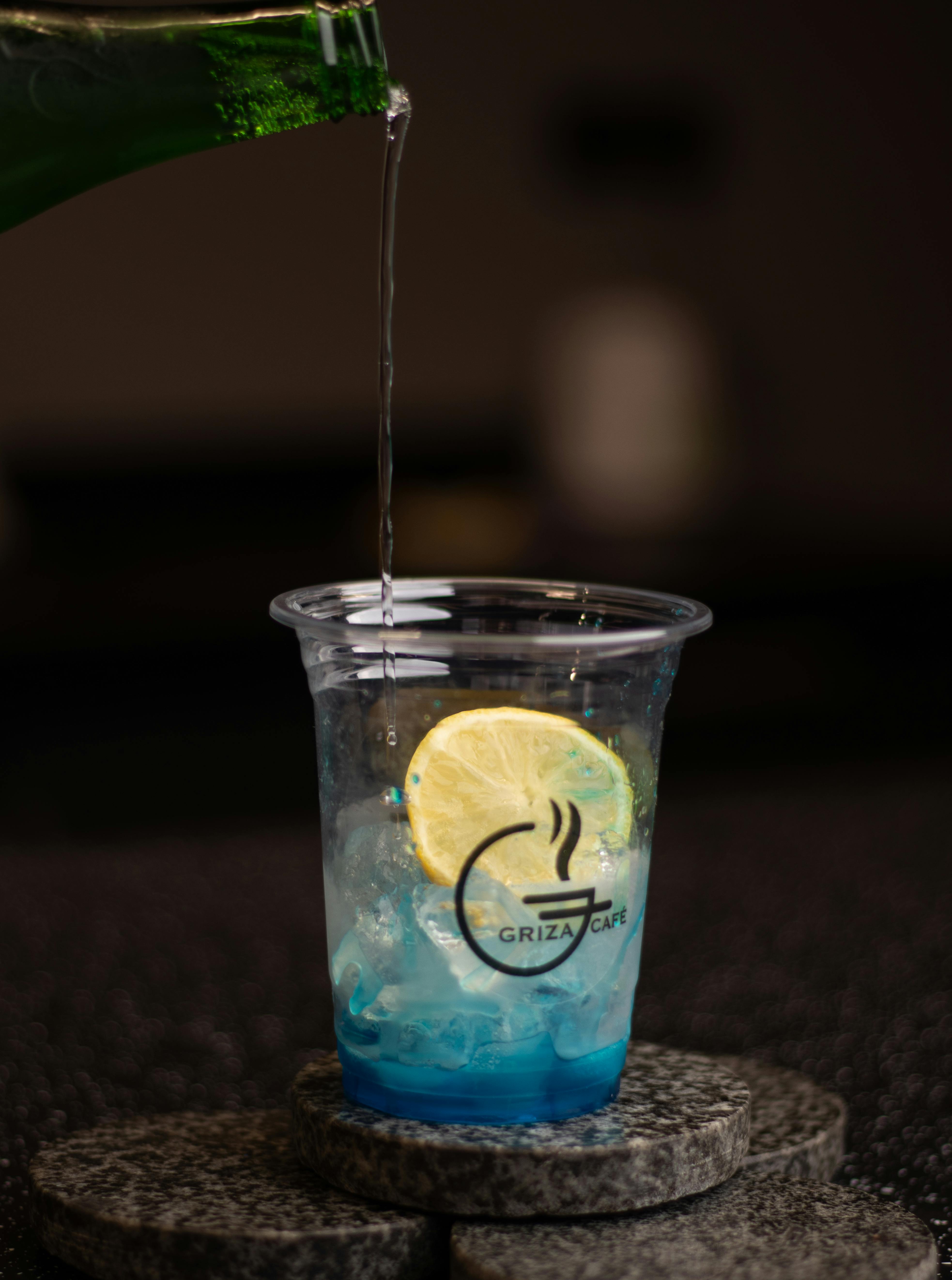 Pouring of Liquid in a Disposable Cup with Ice and Sliced Lemon · Free ...