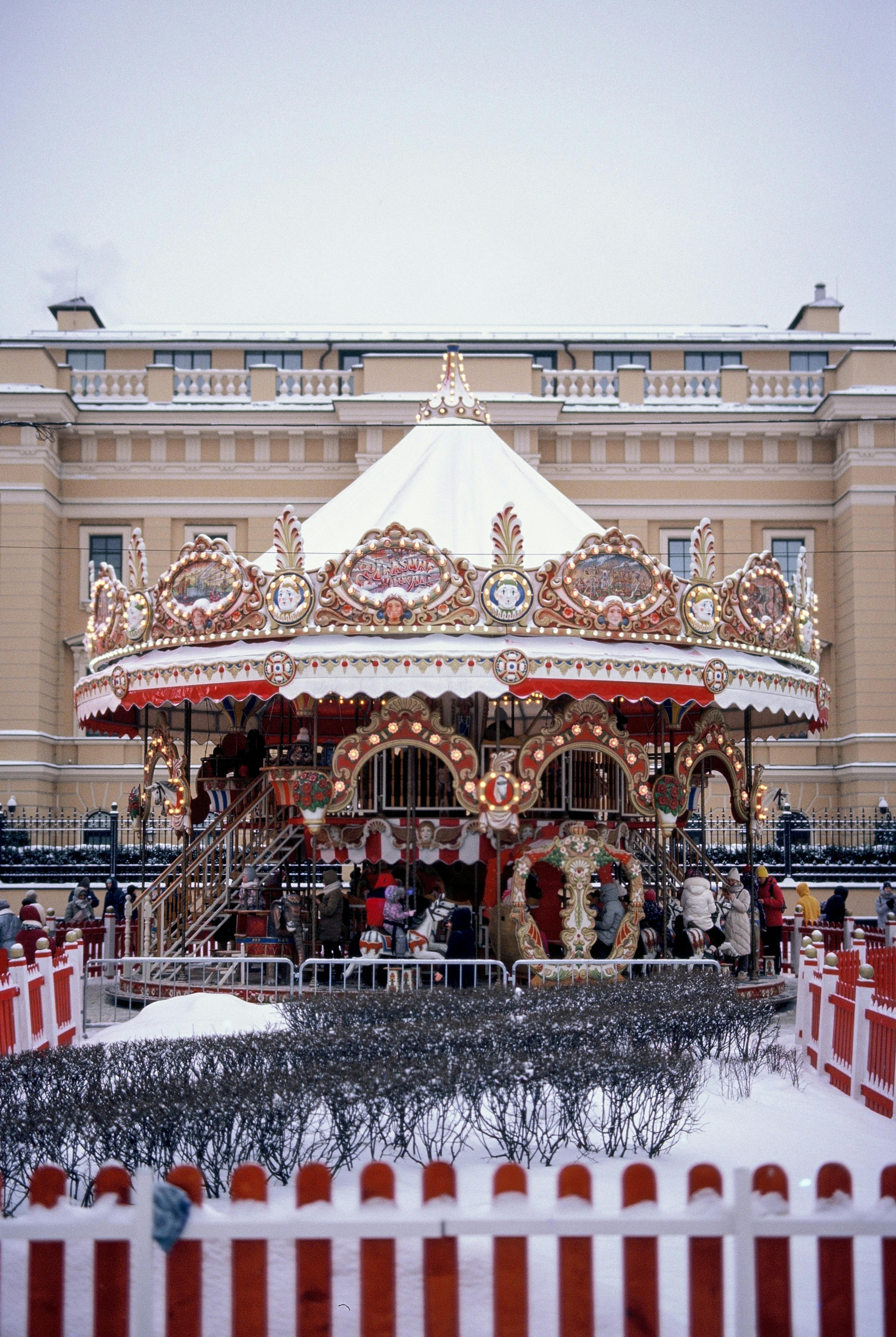 Ornate Carousel in front of a Castle Buildings in Winter · Free Stock Photo