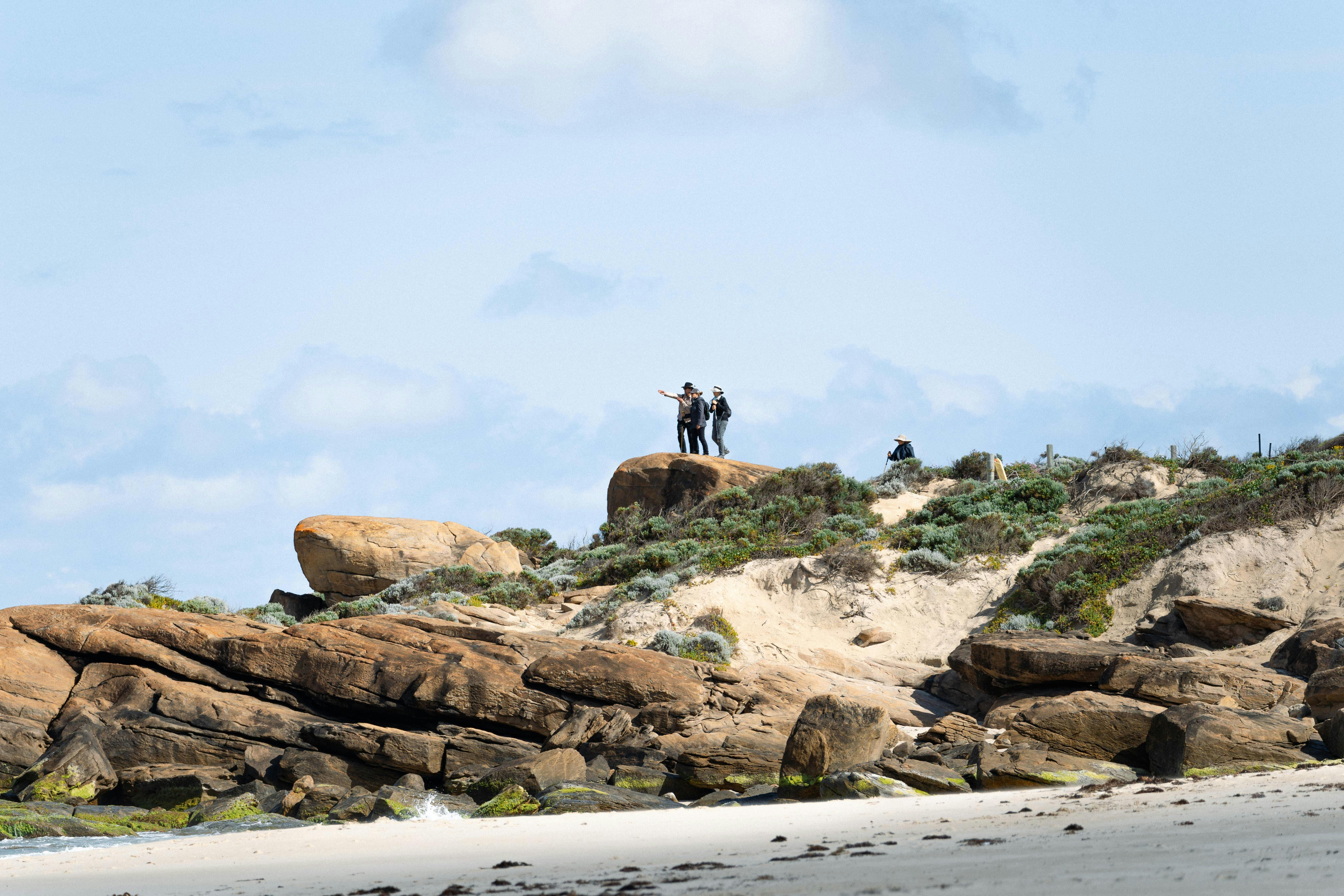 Low Angle Shot of People Standing on Cliff · Free Stock Photo
