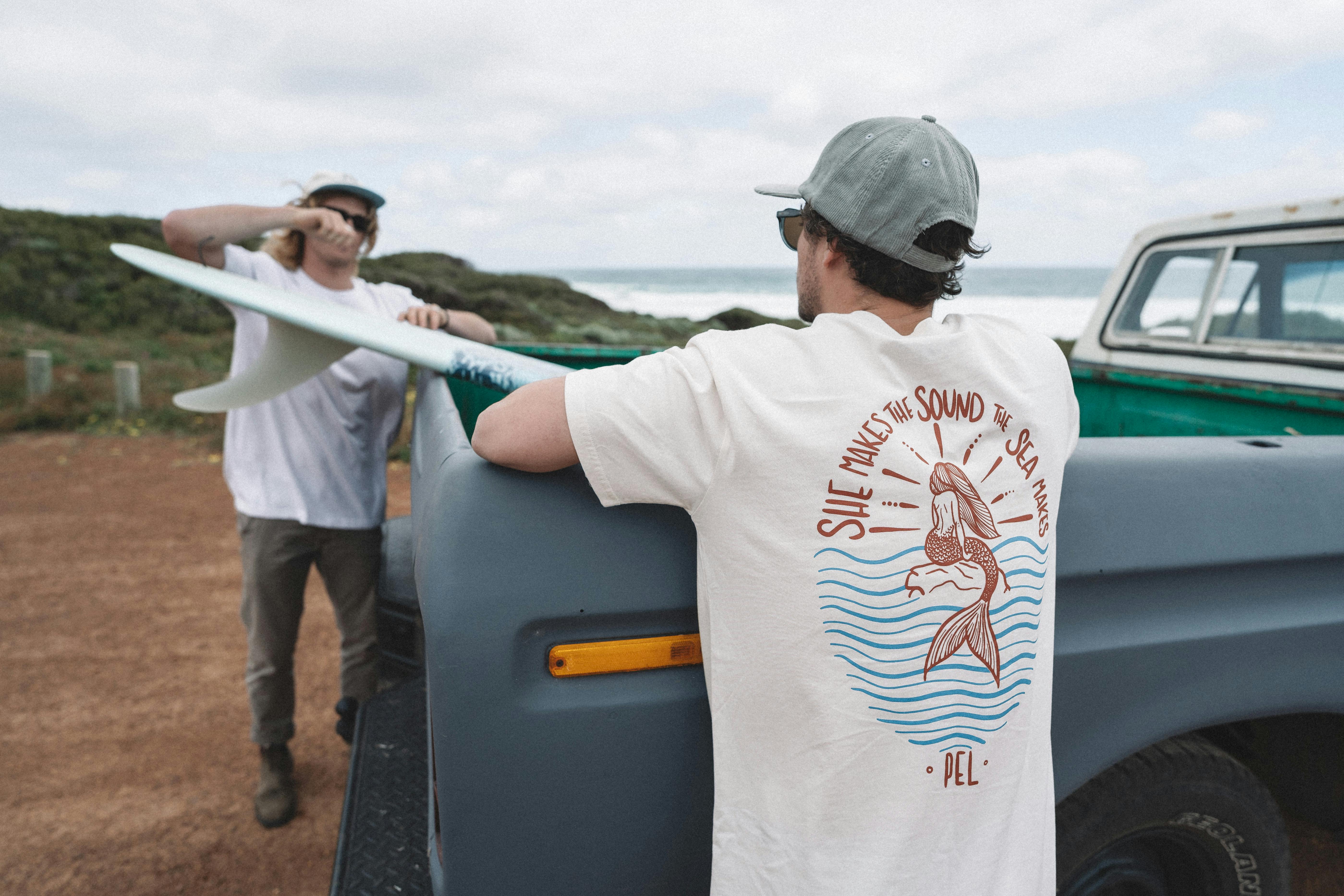 Two Surfers Standing by a Pickup Truck · Free Stock Photo