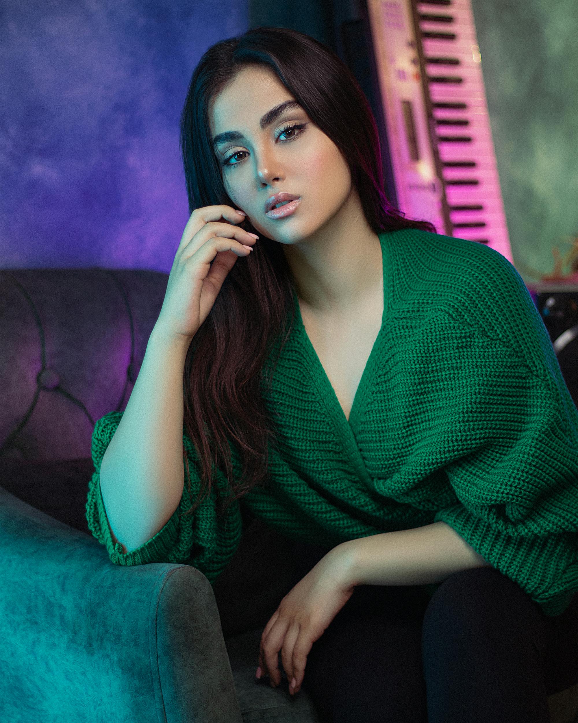 Woman in Green Knitted Top Sitting on a Purple Sofa · Free Stock Photo