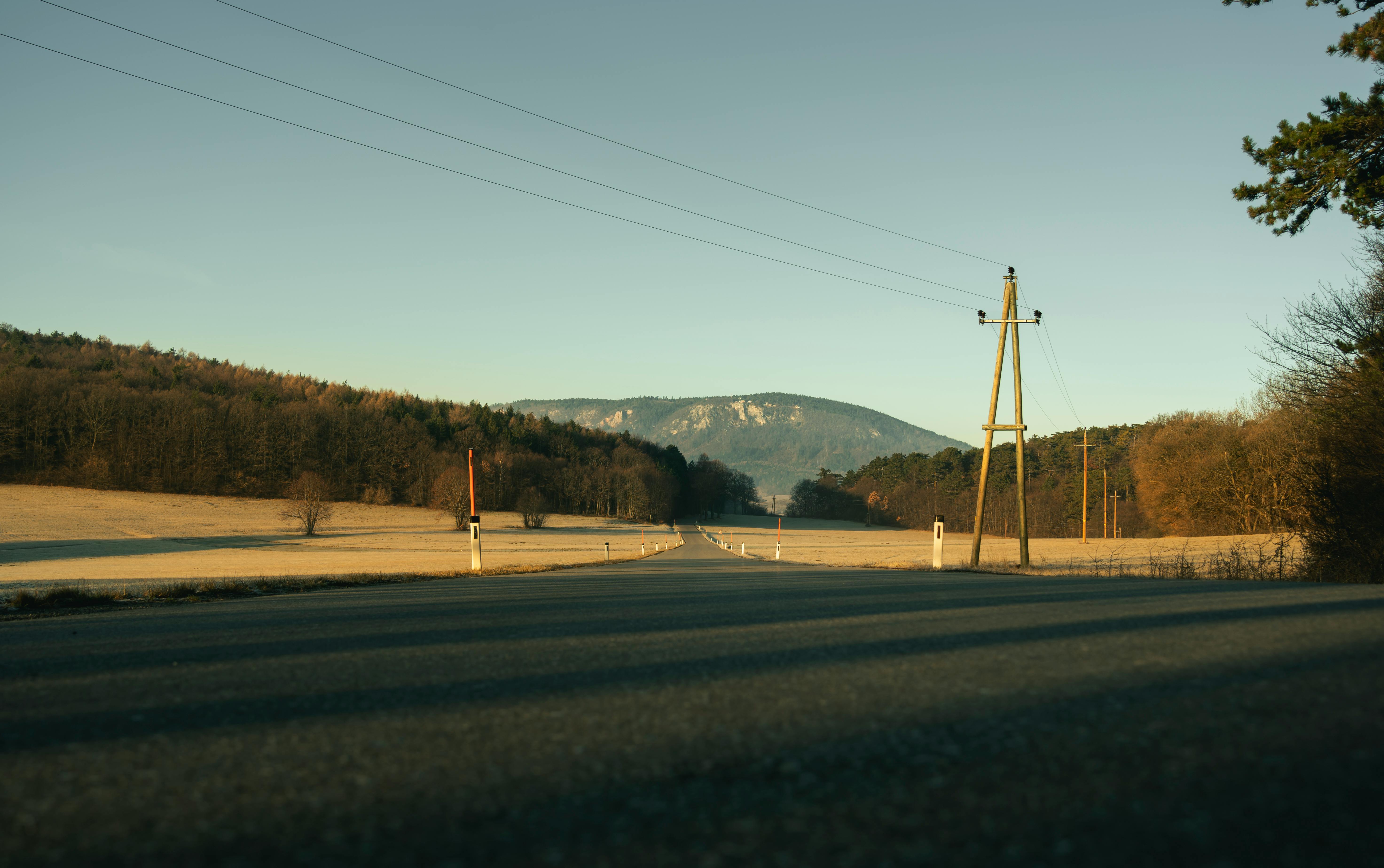 Gray Electric Post on Gray Asphalt Road · Free Stock Photo