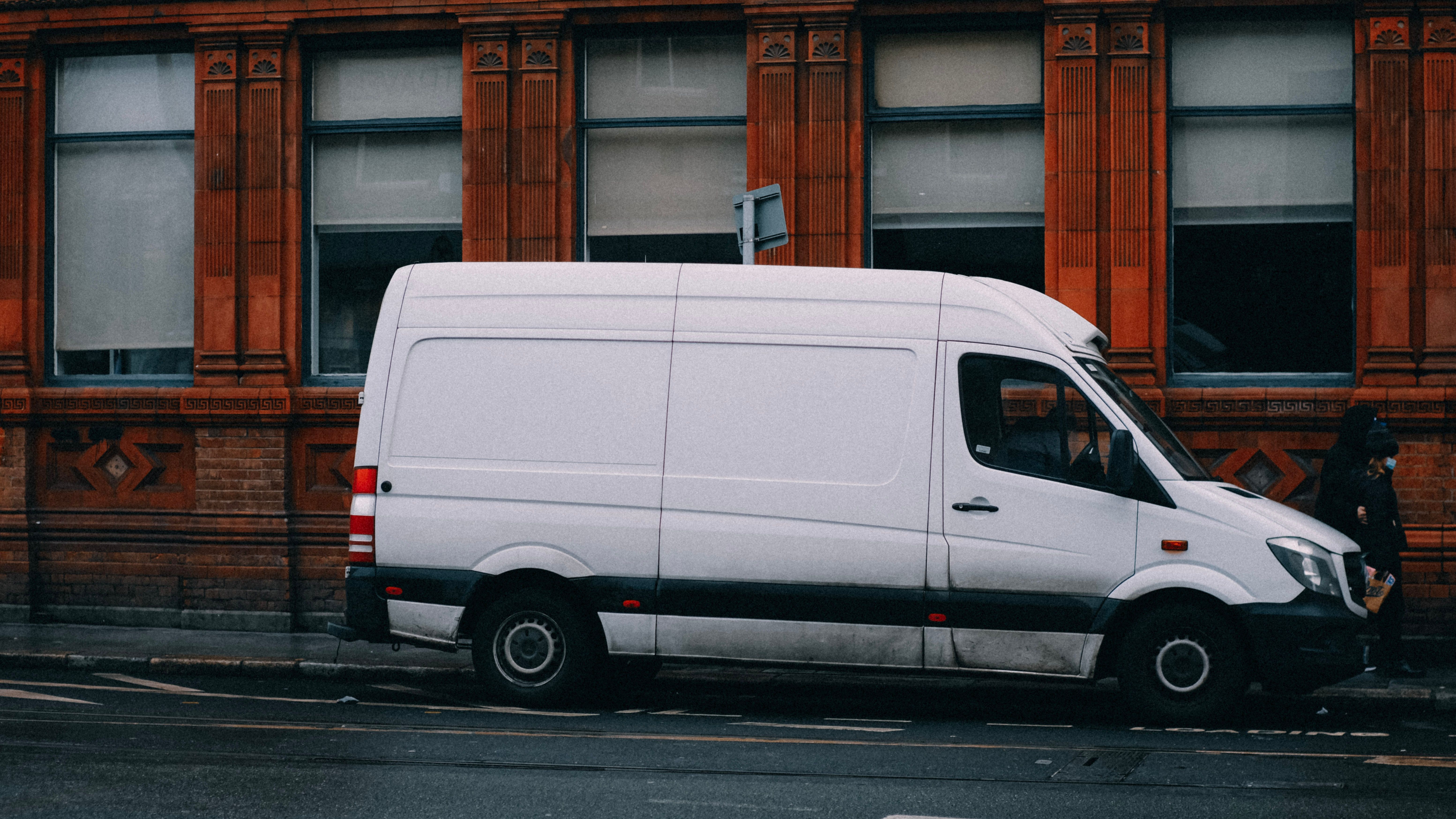 A Side View of a White Van Driving a Road at Highlands · Free Stock Photo
