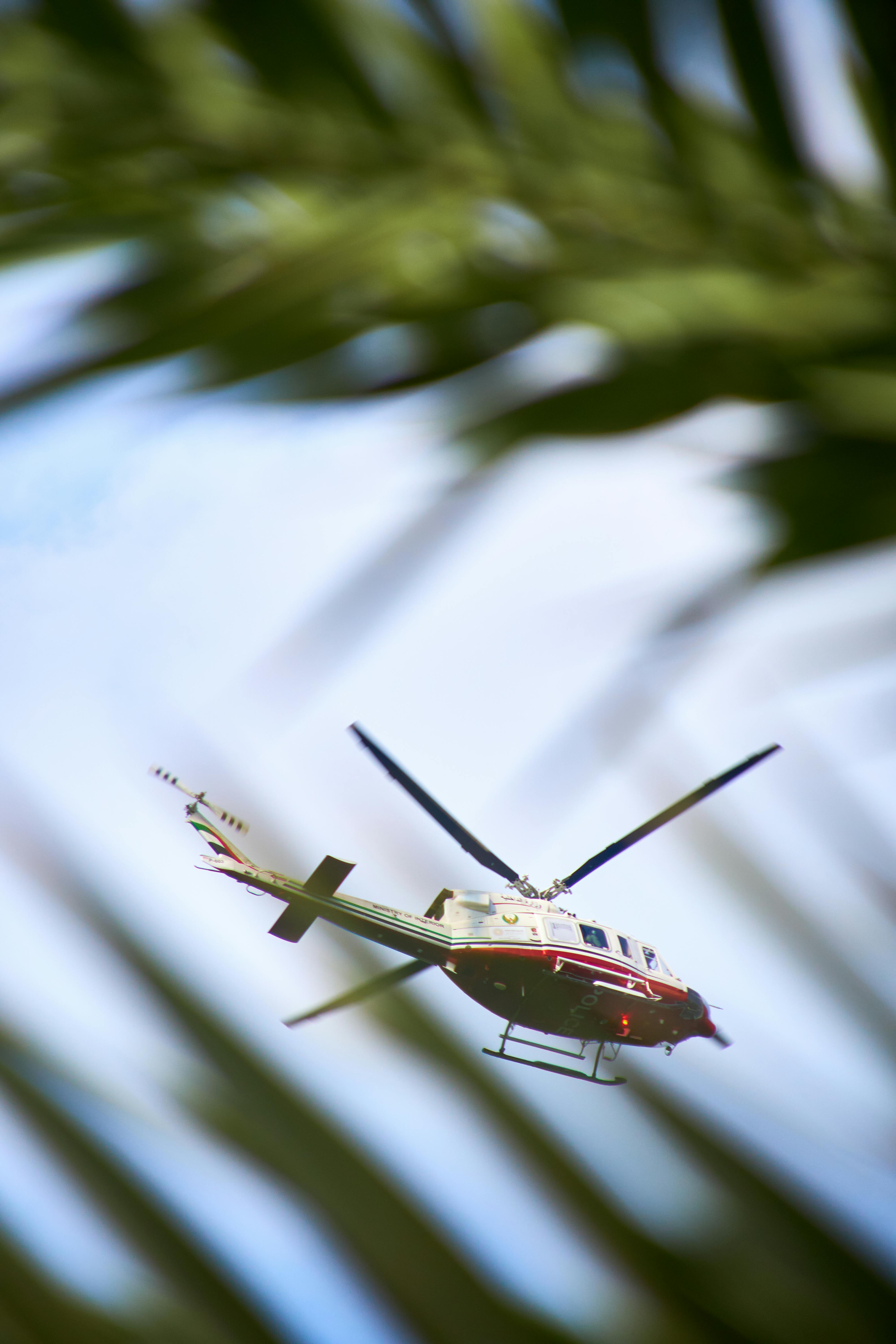A Red and White Helicopter Flying in the Sky · Free Stock Photo