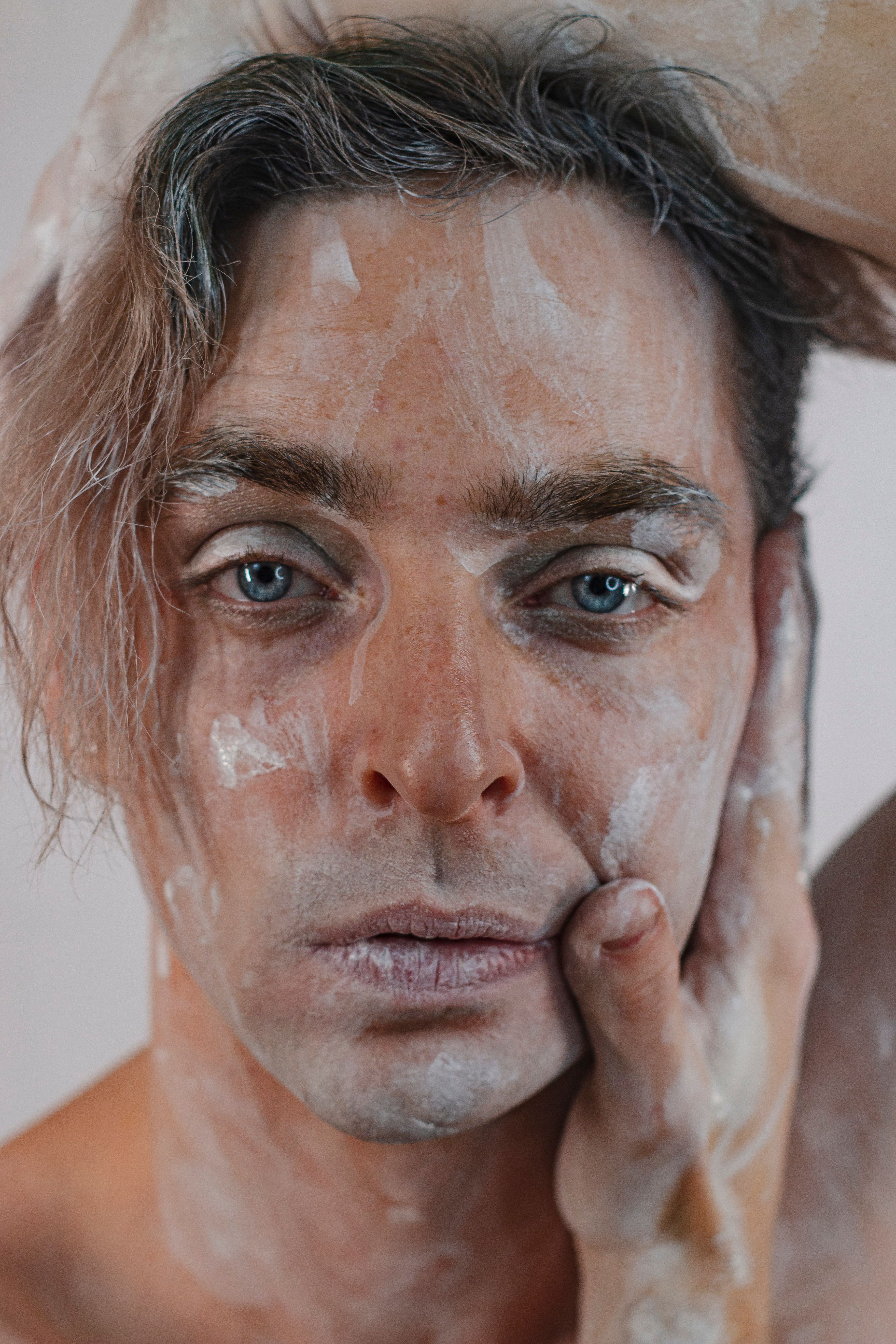 Man Covered in White Powder with Hands on his Face · Free Stock Photo