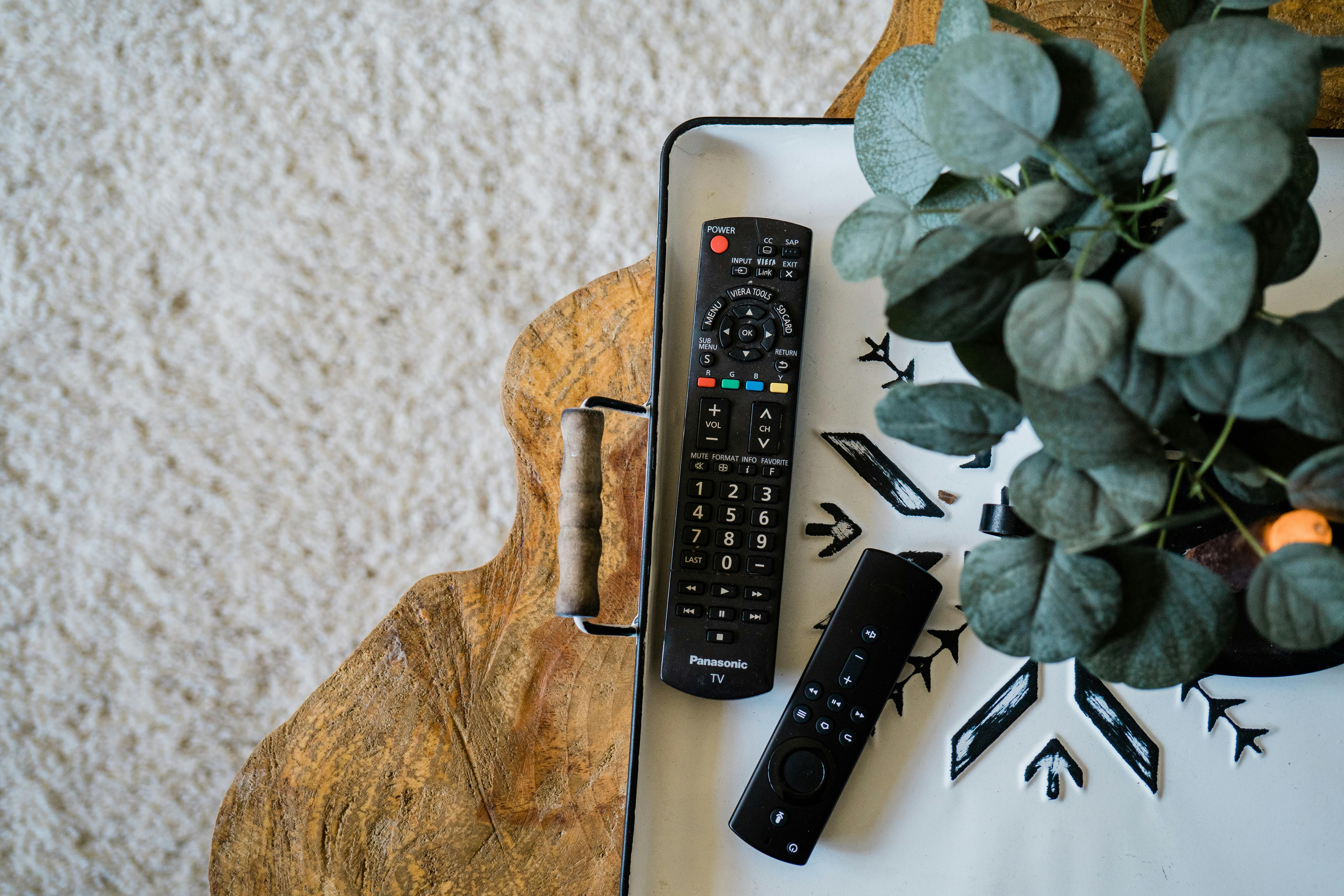 Black Remote Controls on Brown Wooden Table · Free Stock Photo