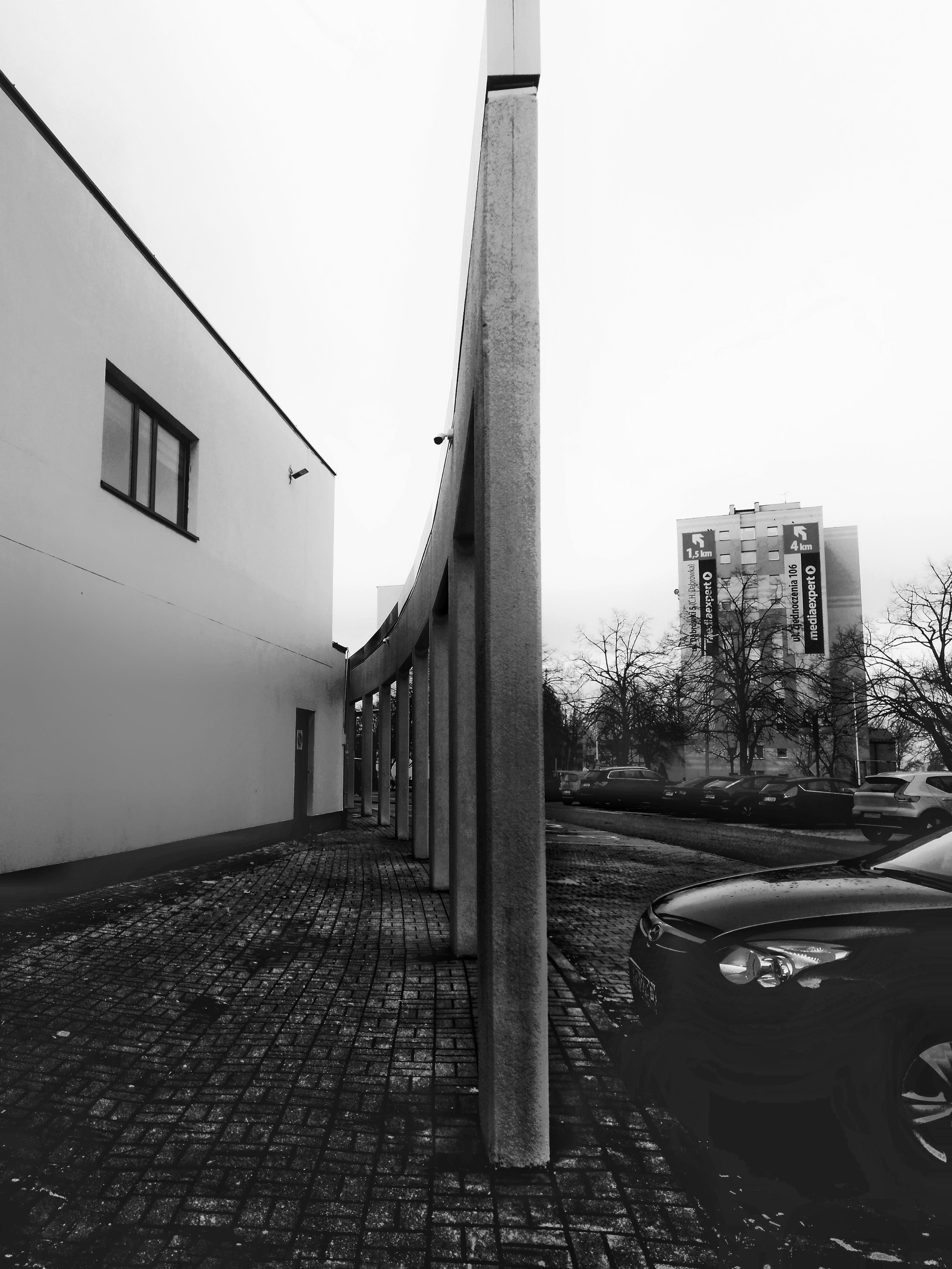 Parked Car by a Concrete Structure · Free Stock Photo