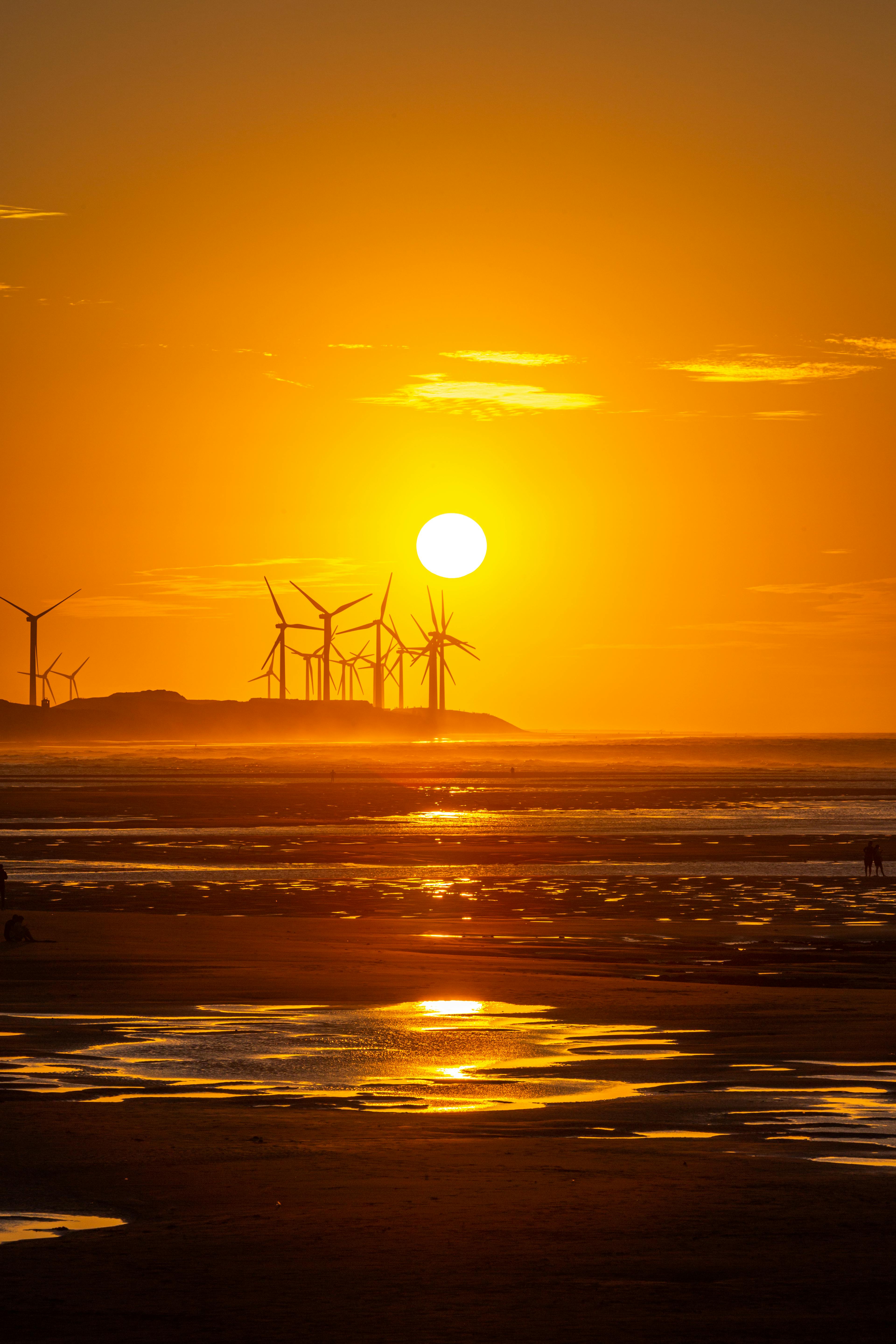 Sunset over Beach with Wind Turbines in Background · Free Stock Photo
