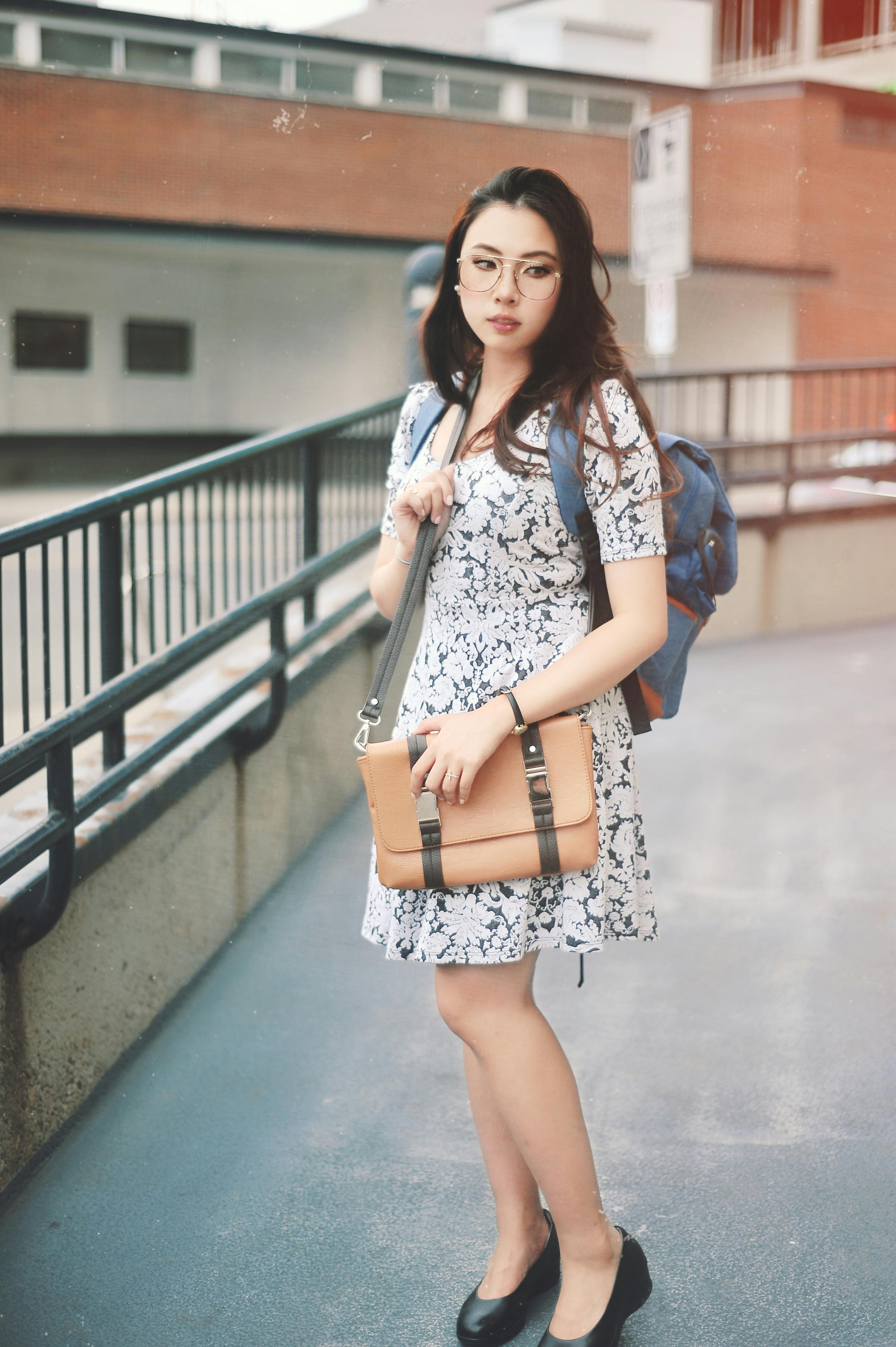 Woman in Floral Dress with Back Pack and Shoulder Bag · Free Stock Photo
