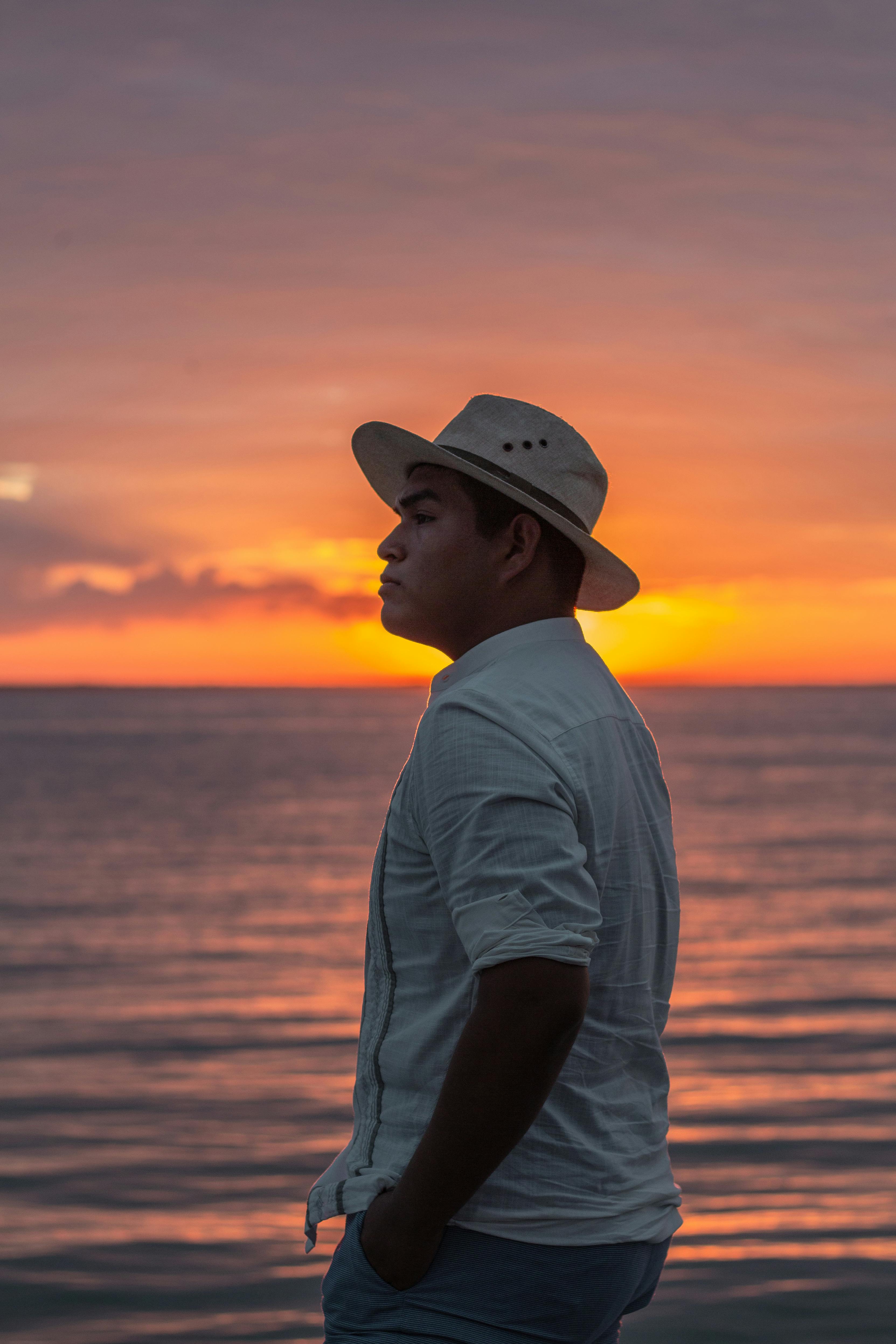 Man Looking Afar while Standing near the Ocean during Golden Hour ...