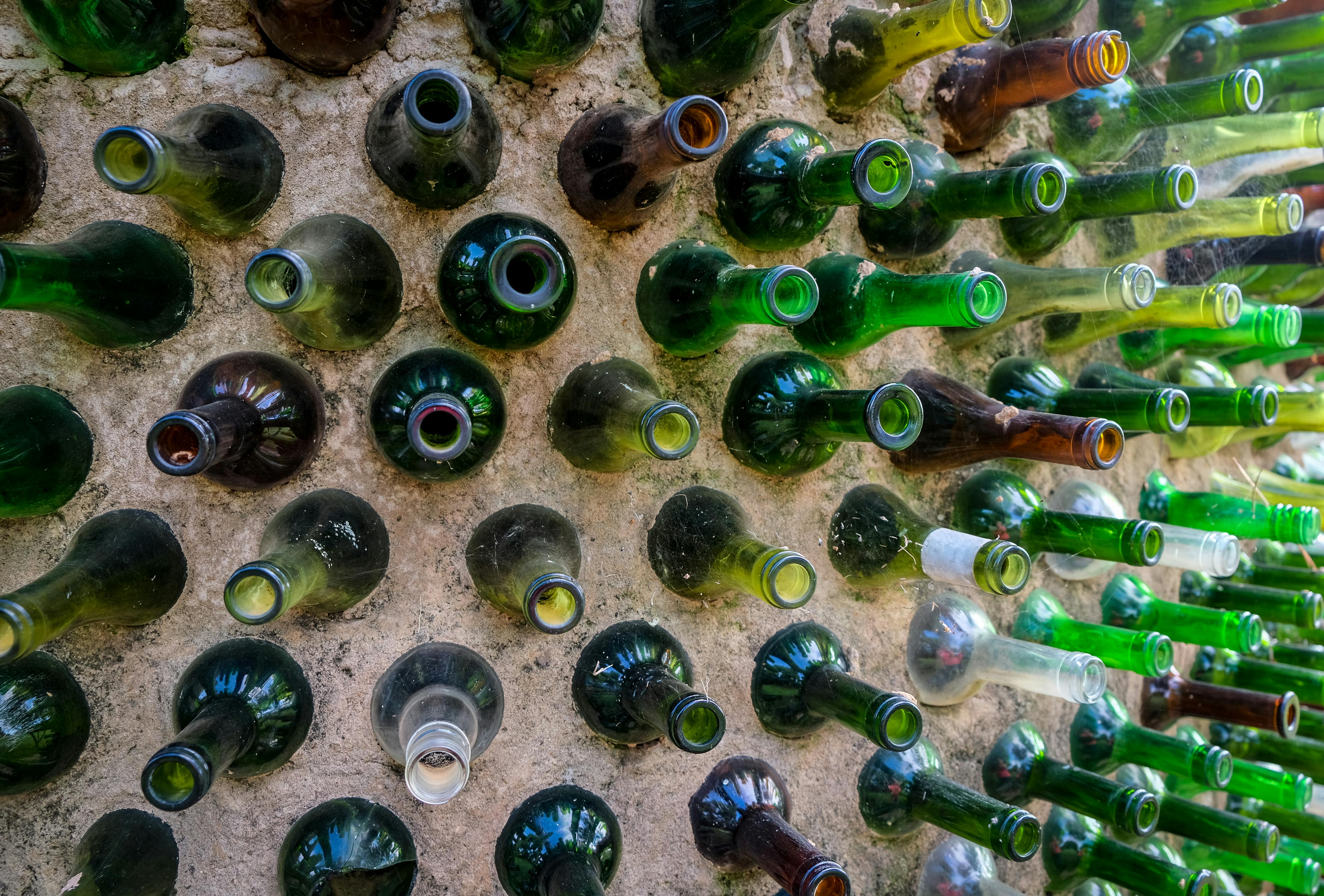 Colored Glass Bottles on Brown Sand · Free Stock Photo