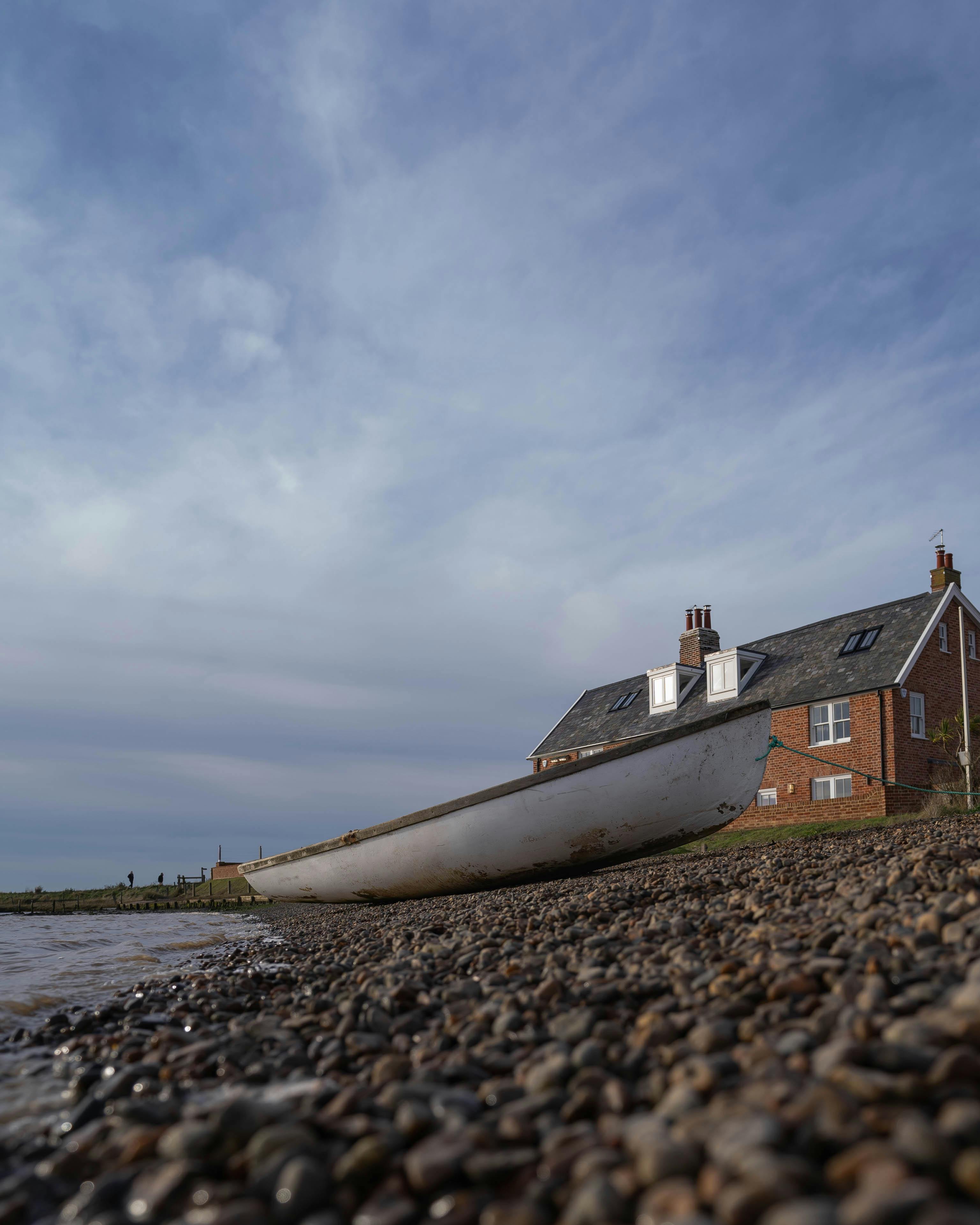 A Boat Moored on the Ground Near Water · Free Stock Photo