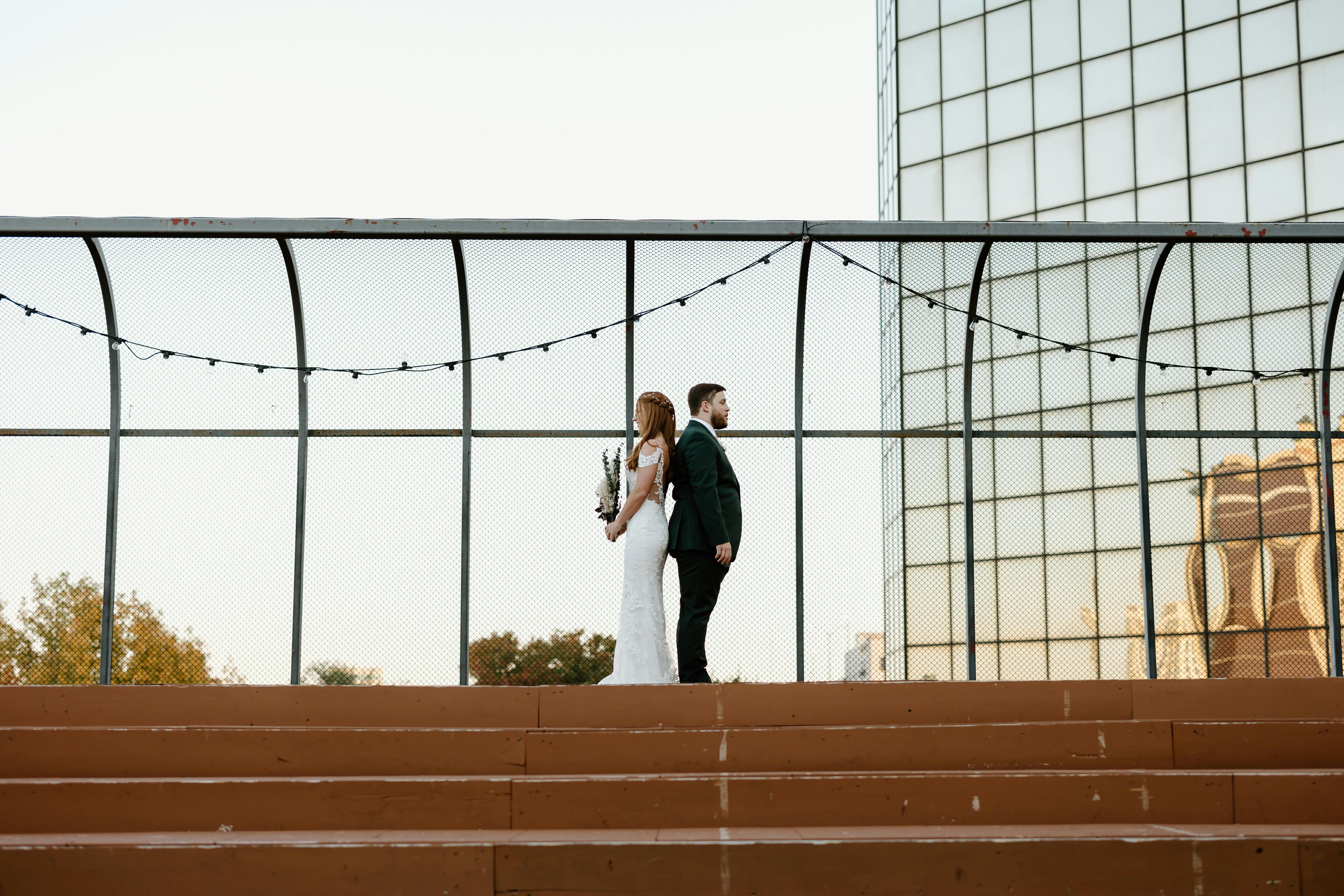 Bride and Groom Standing Back to Back on Top of Bleachers · Free Stock ...