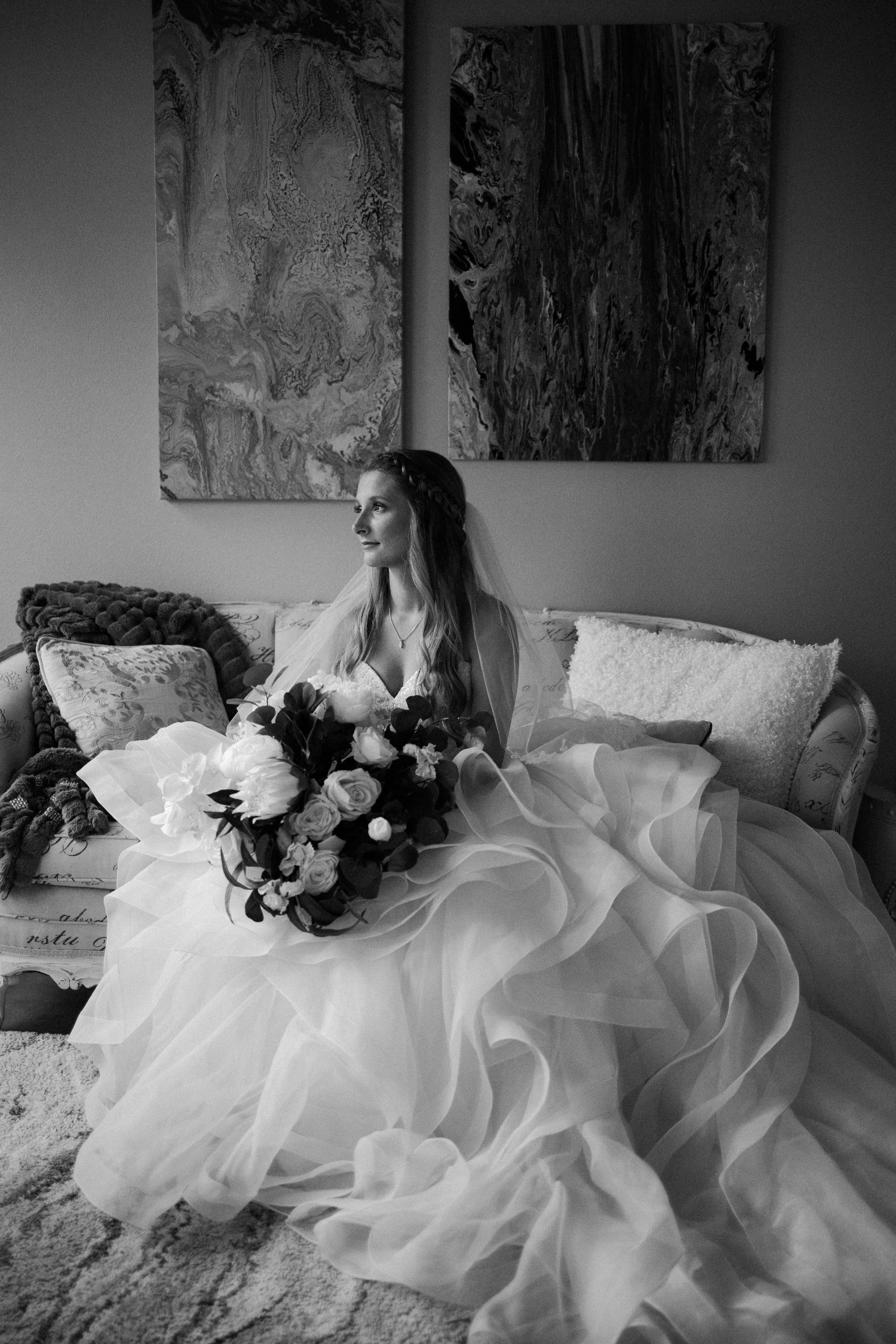 Bride in Wedding Dress Sitting on Couch with Bouquet of Flowers · Free ...