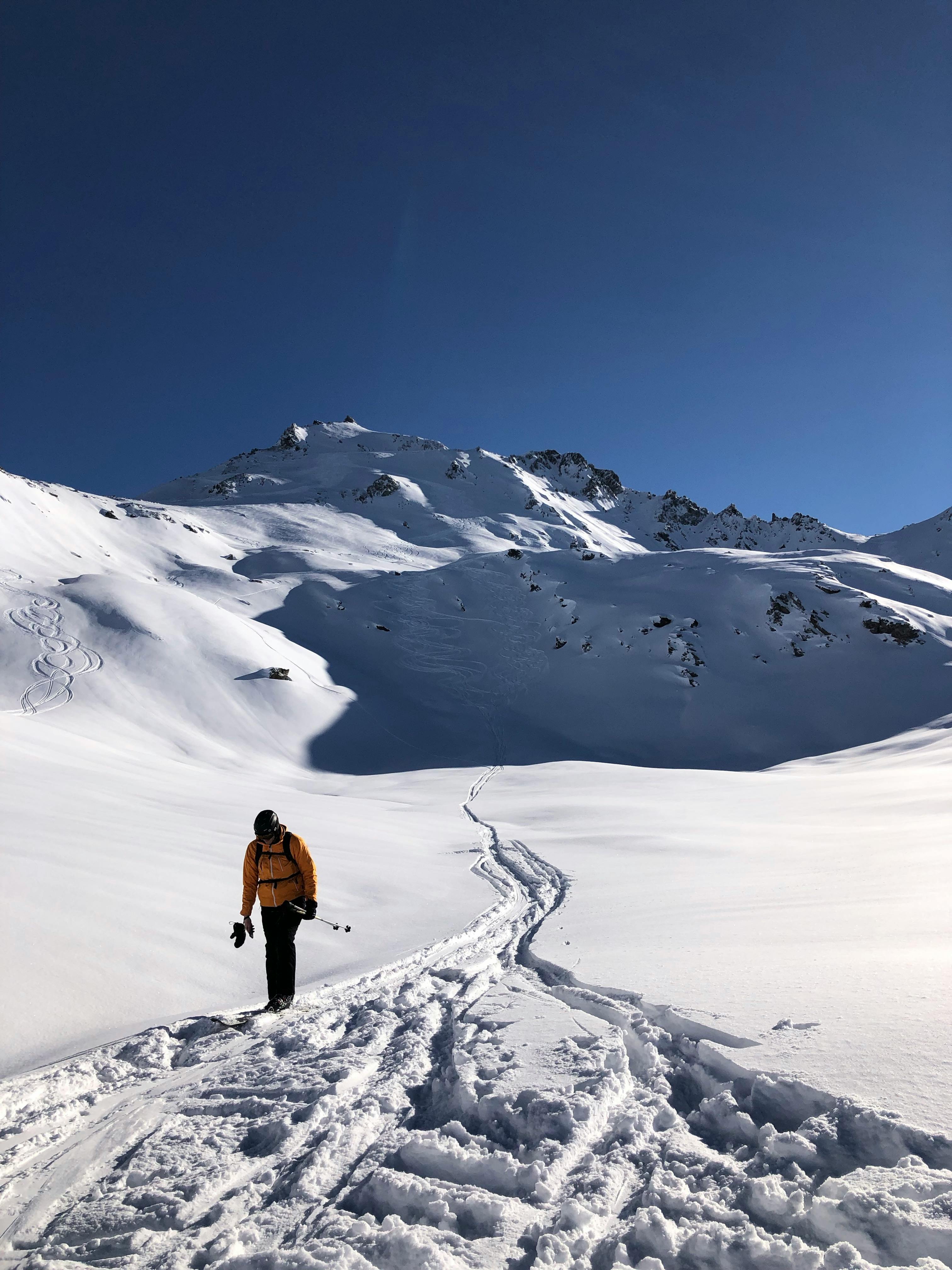 Hiker Walking on Trail in Snowy Mountains · Free Stock Photo