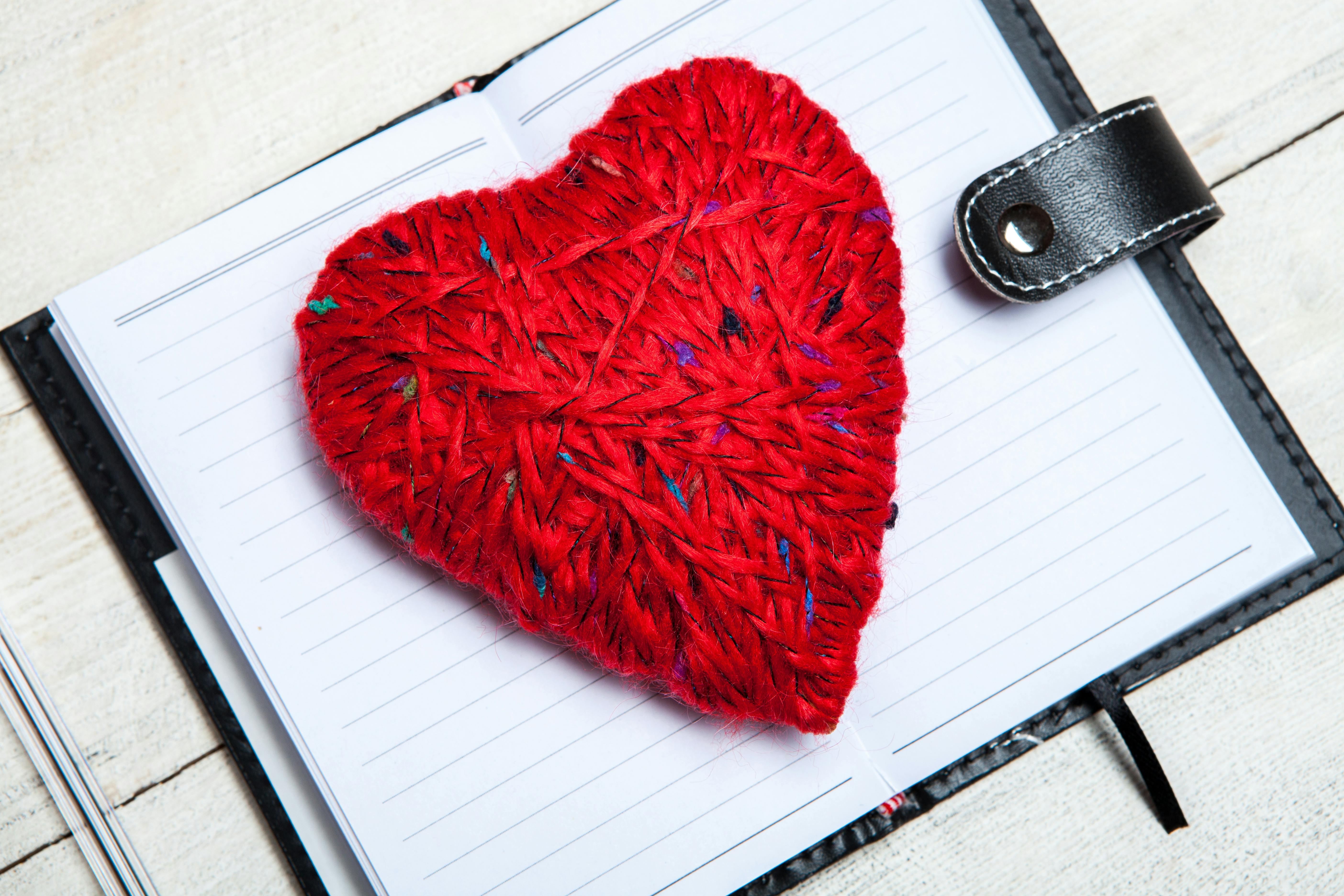 Red Heart Shaped Yarn on White Notebook · Free Stock Photo