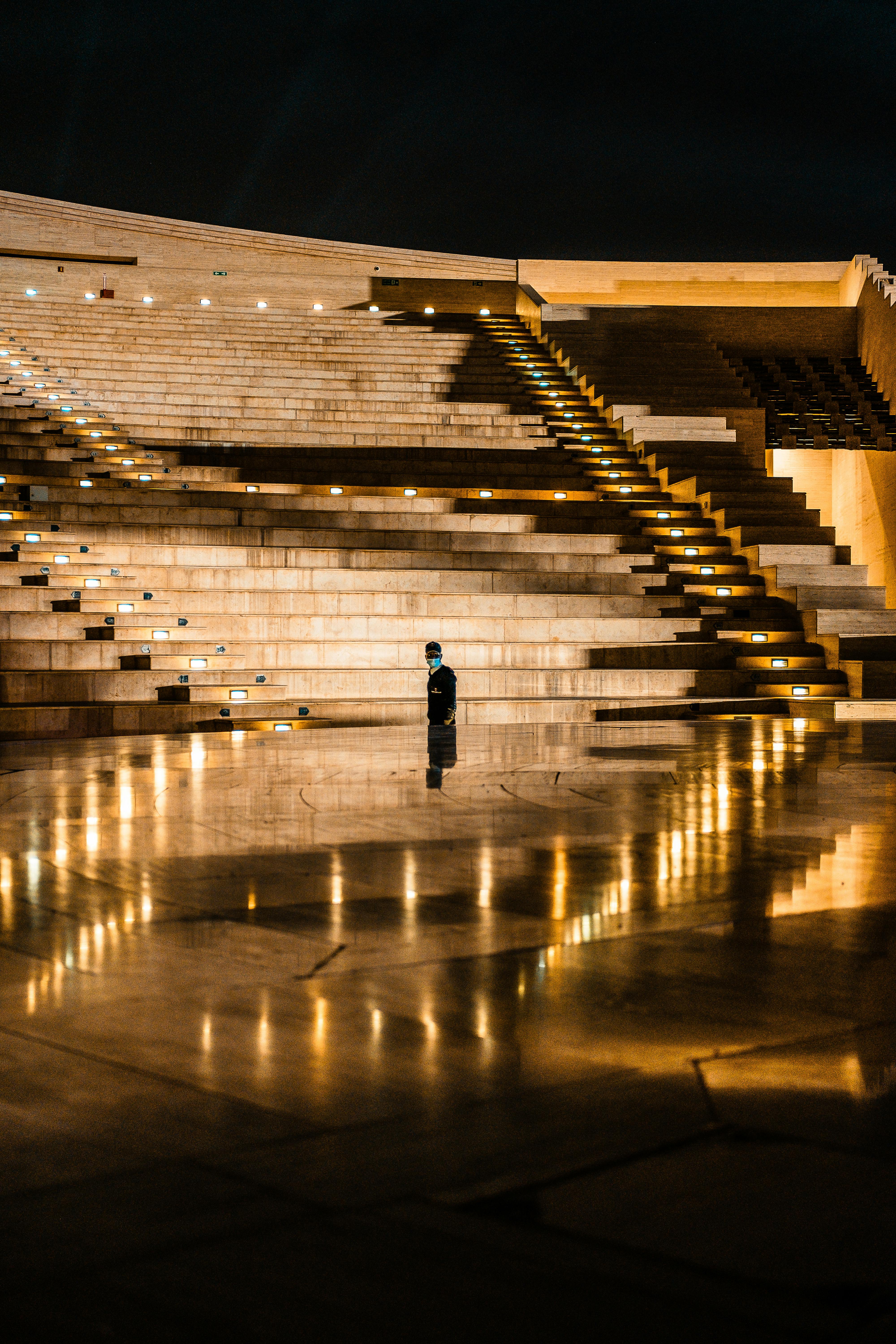 A Person Standing in an Amphitheater at Night · Free Stock Photo