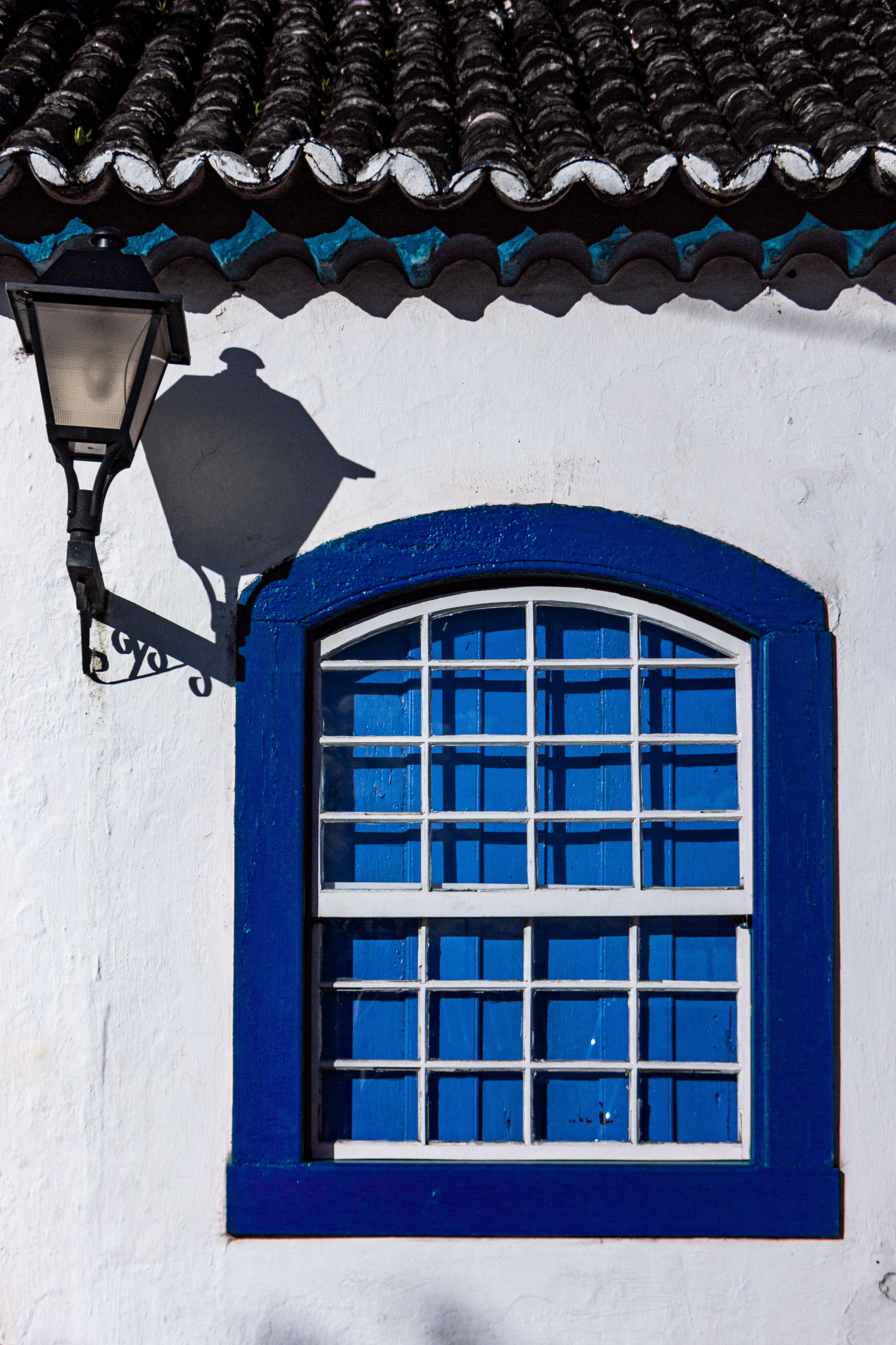 Wall Lamp Near Blue Glass Window · Free Stock Photo