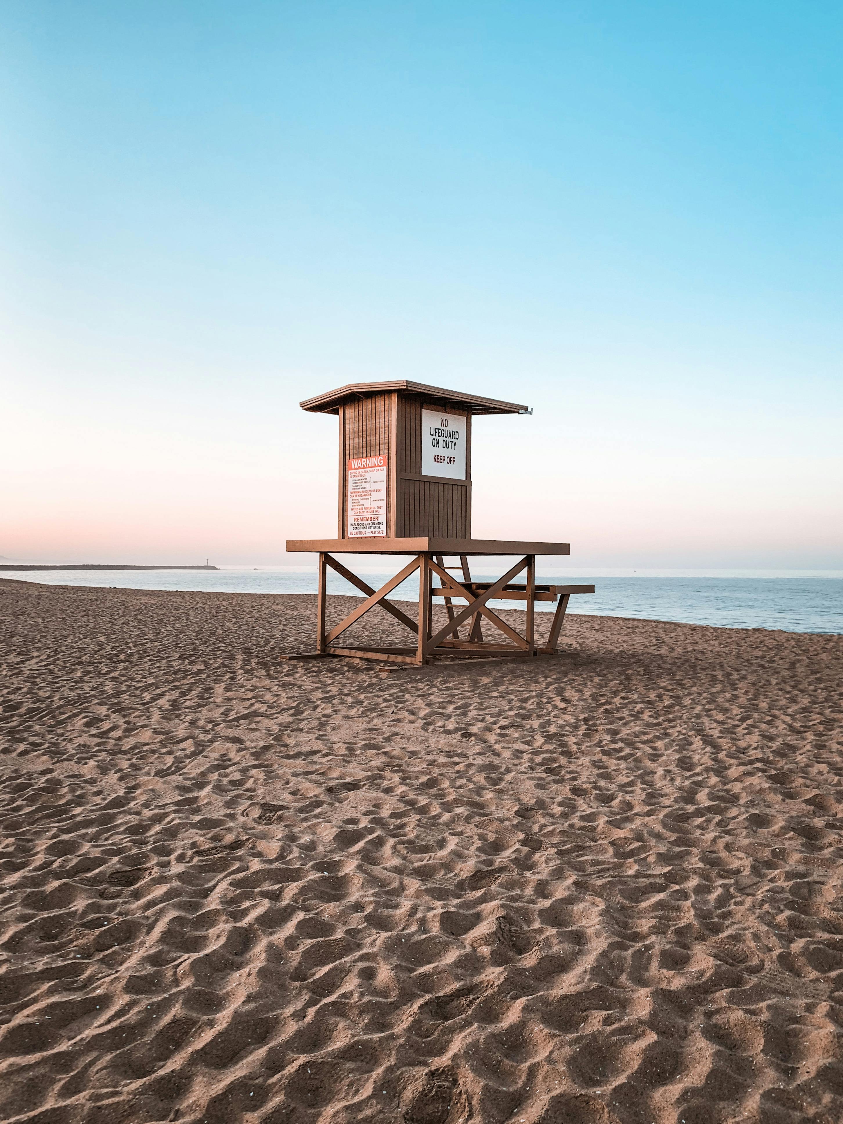 Lifeguard building on seashore against sundown sky · Free Stock Photo